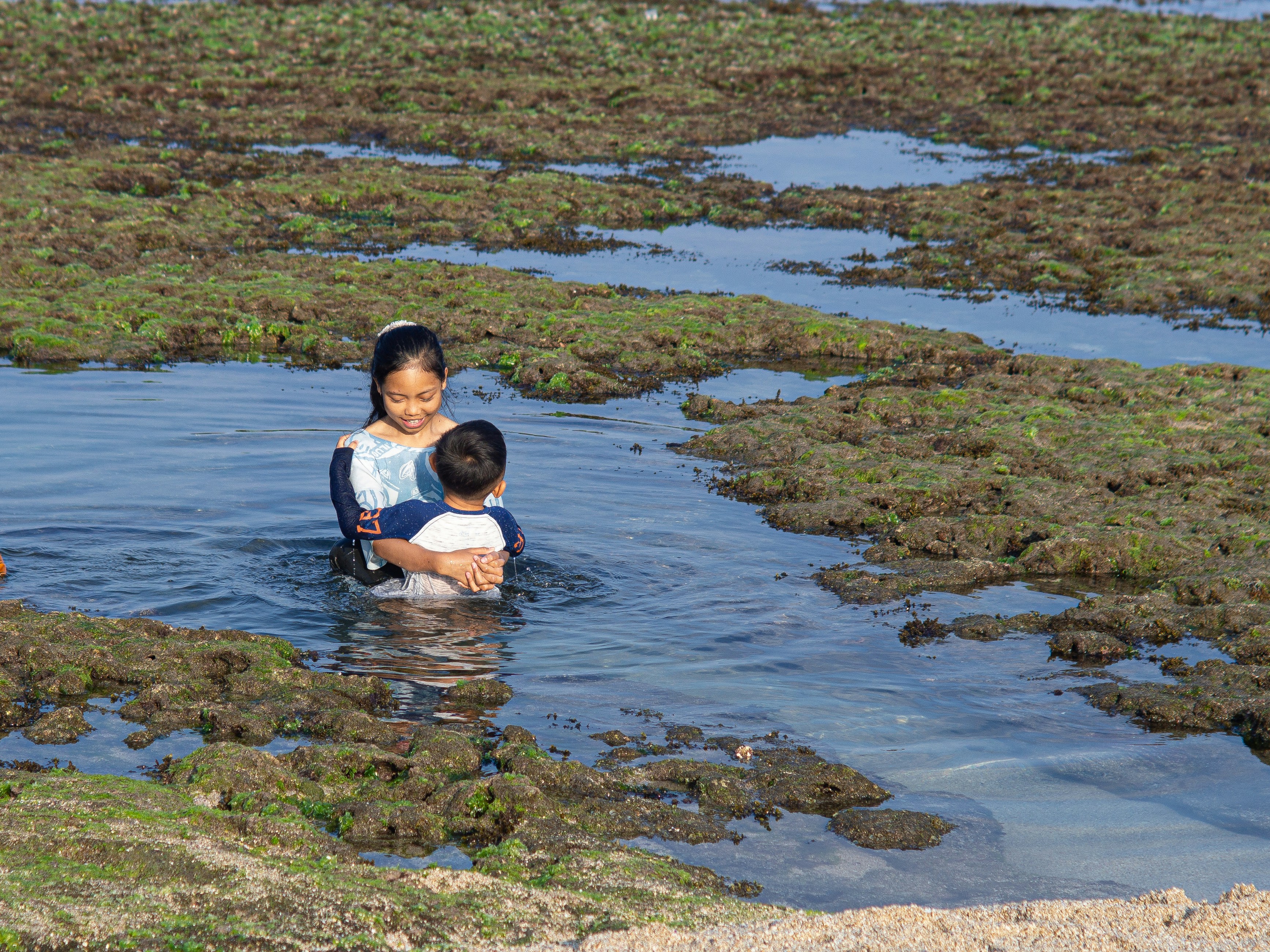 OLYMPUS DIGITAL CAMERA | Mother and child wading in shallow ocean water