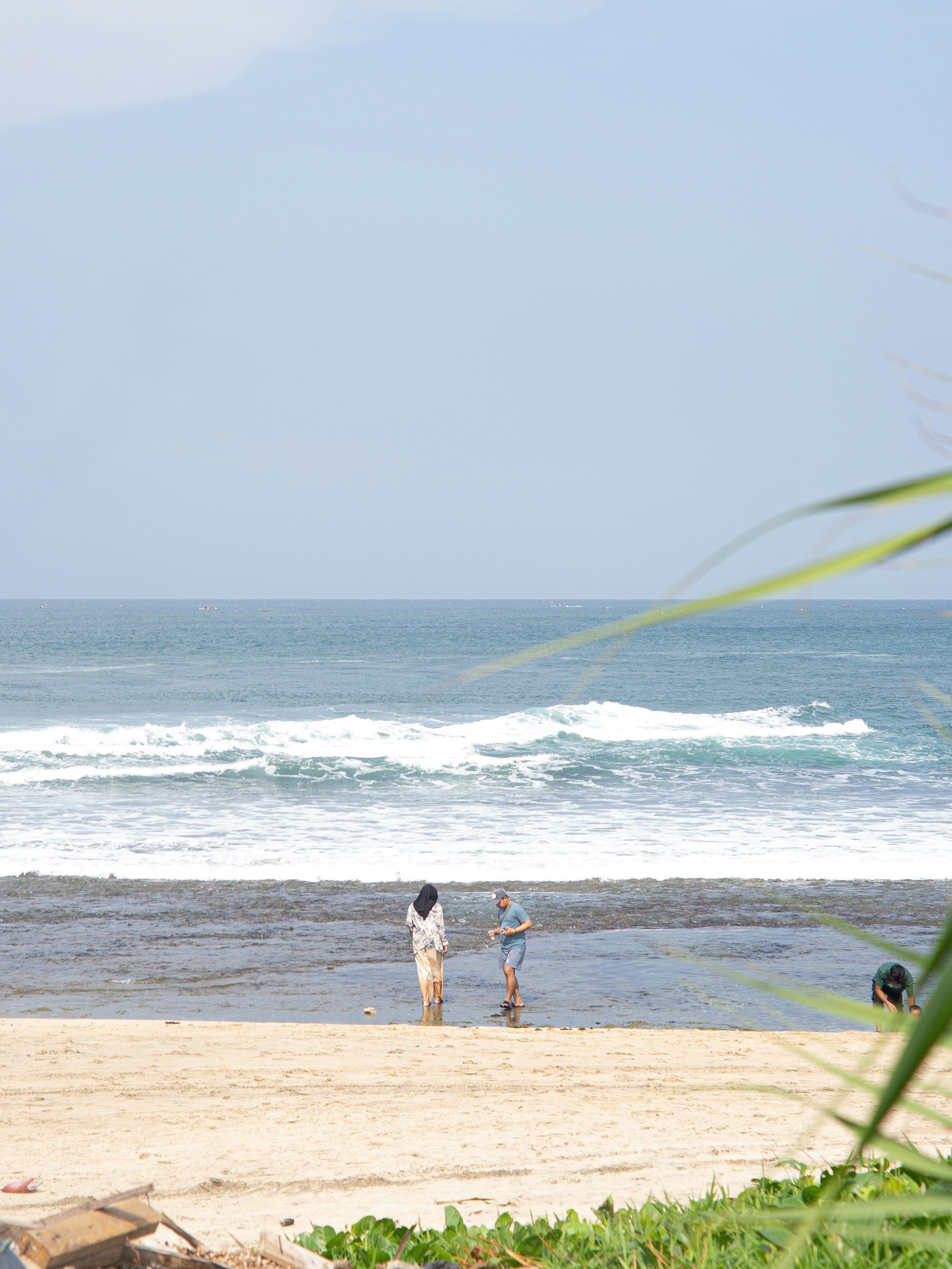 OLYMPUS DIGITAL CAMERA | Two people standing on a beach near the ocean.