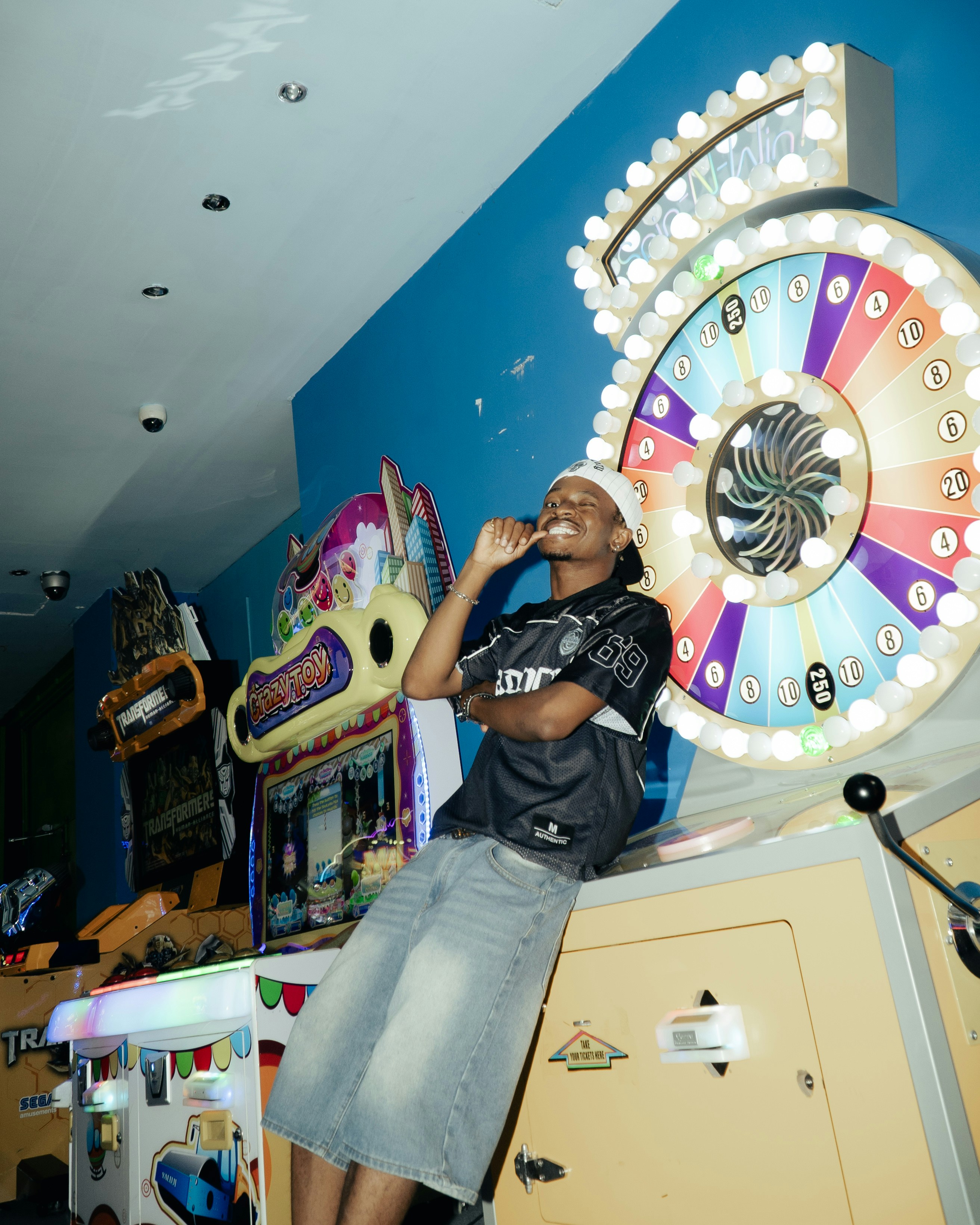 Man in arcade near colorful games and bright game machines