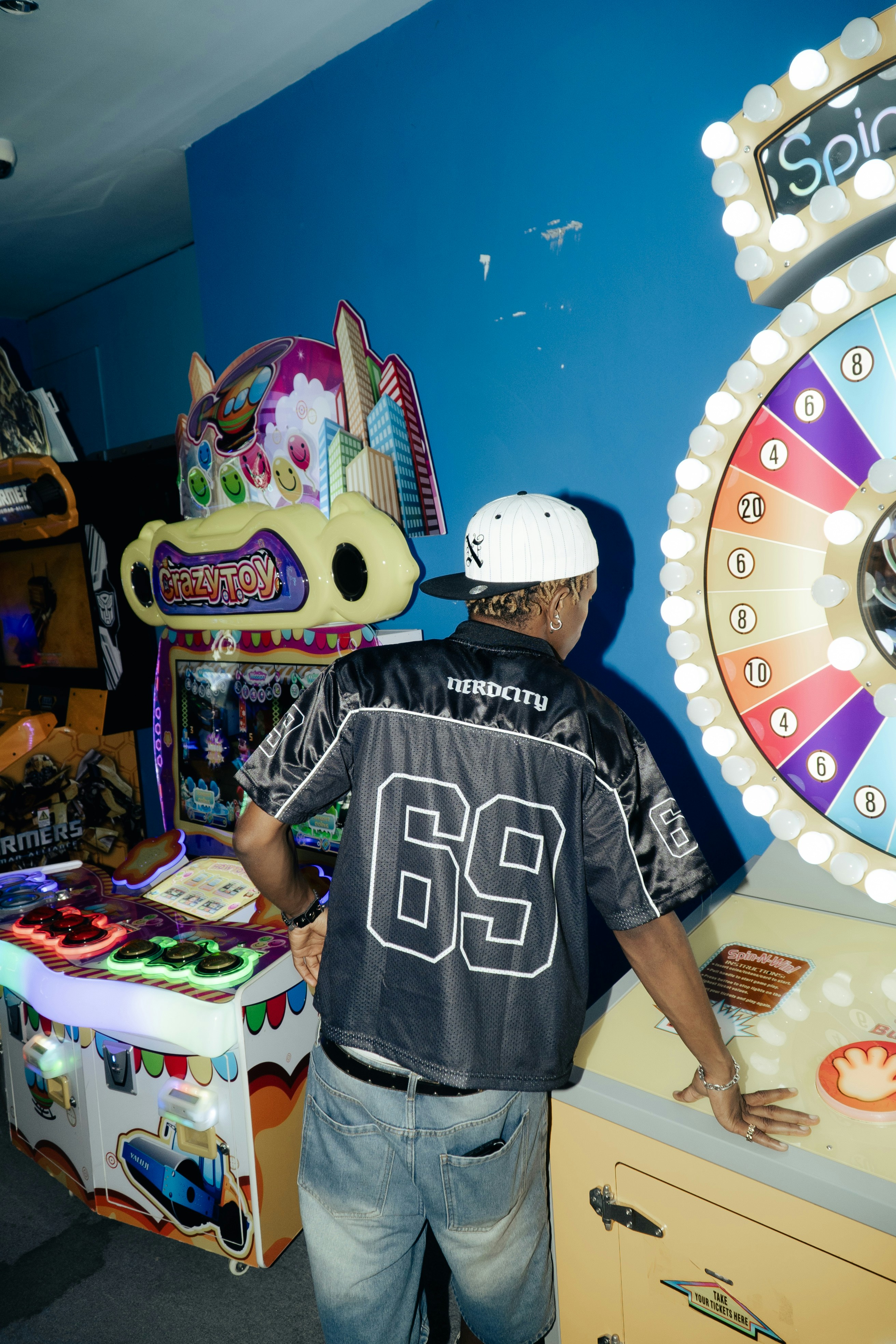 Man playing arcade games in a dimly lit room.