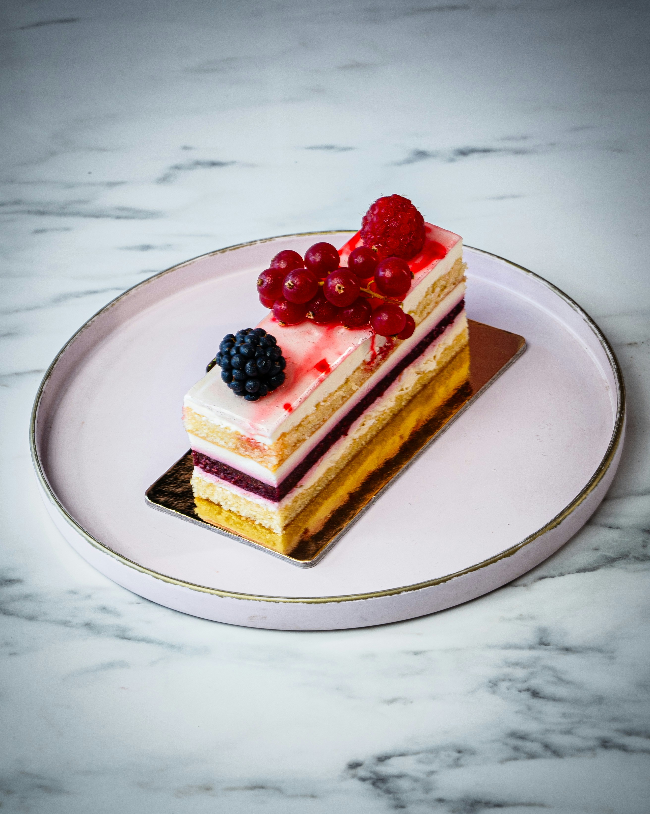 A slice of layered cake with berries on top.
