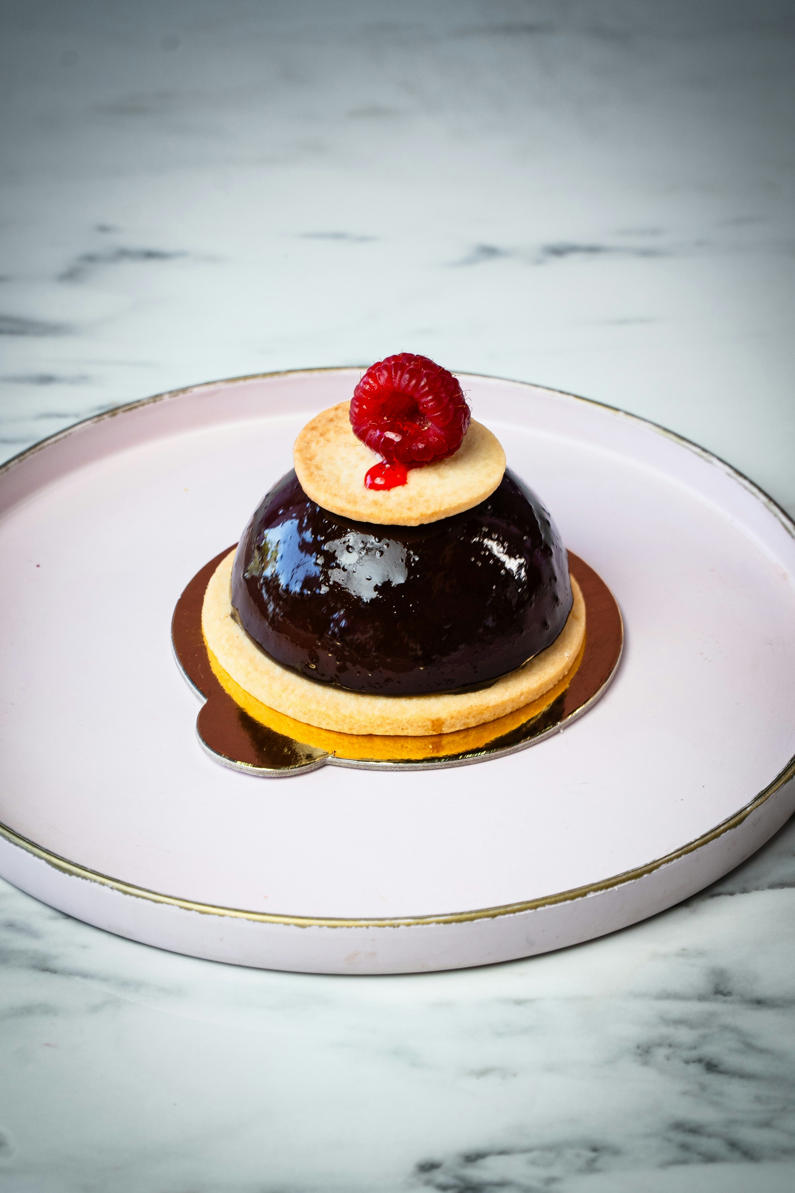 Chocolate dome dessert with raspberry on top