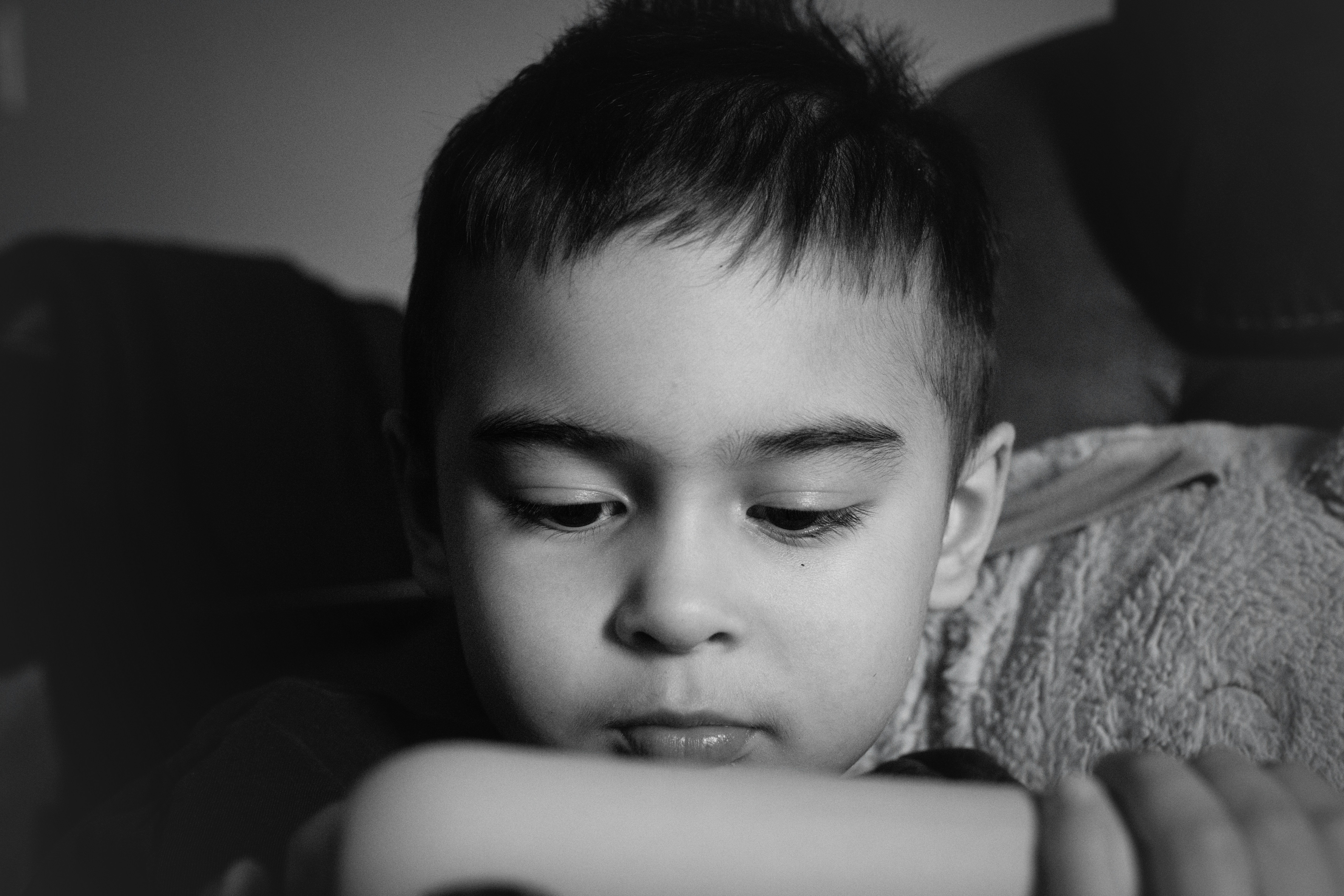 A young boy looking down at something.