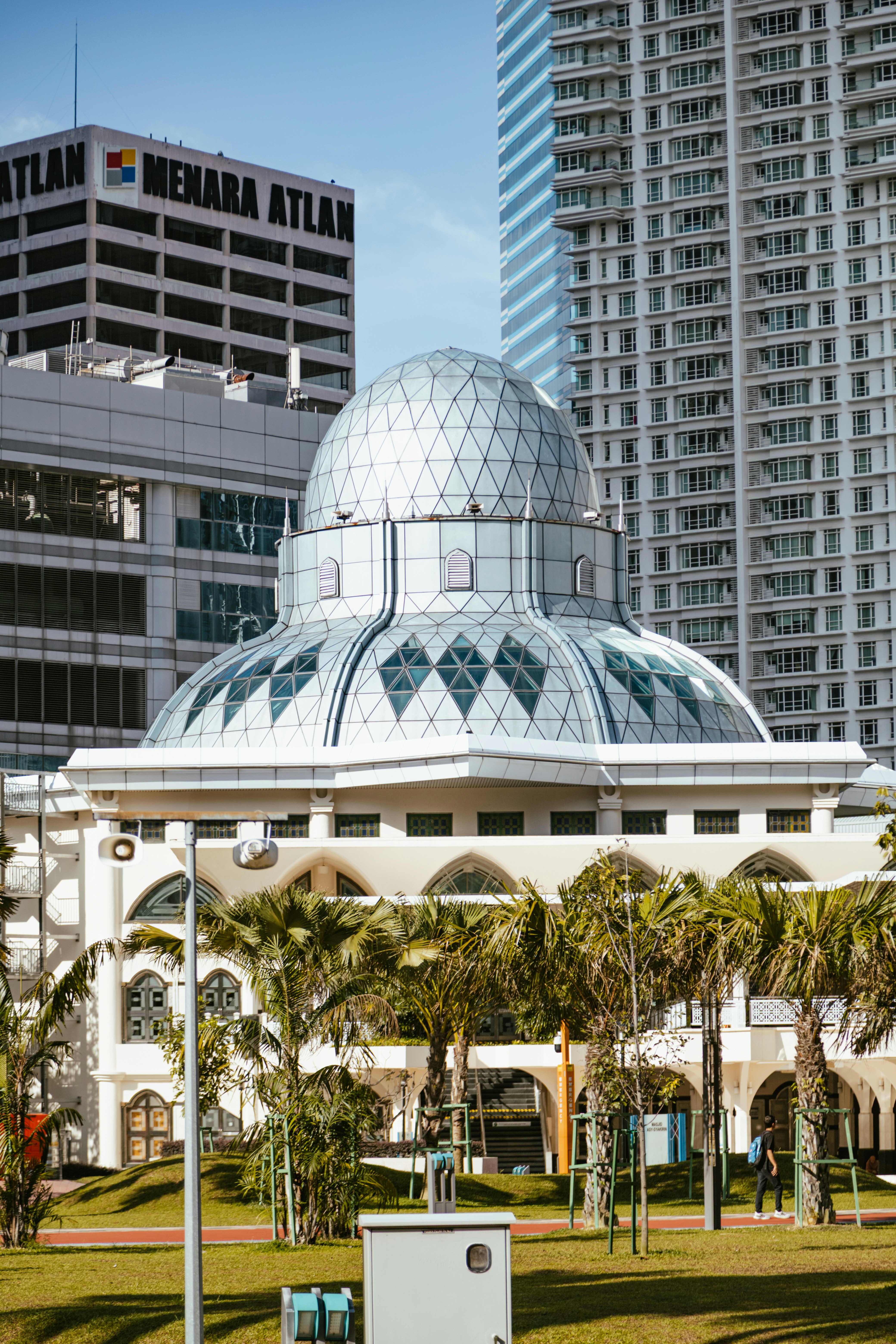 Modern mosque with glass dome surrounded by buildings