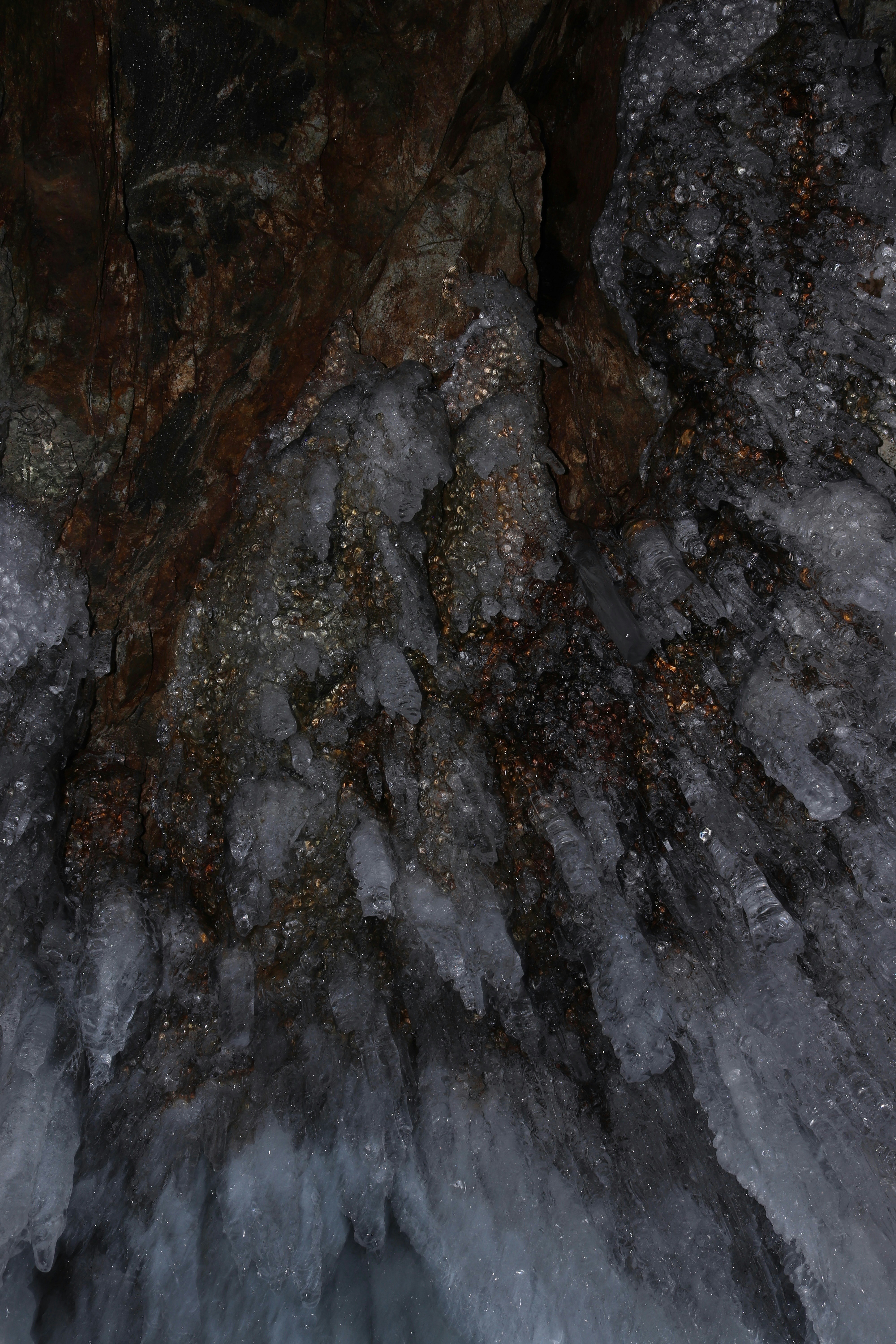 Icicles hanging from a dark cave ceiling