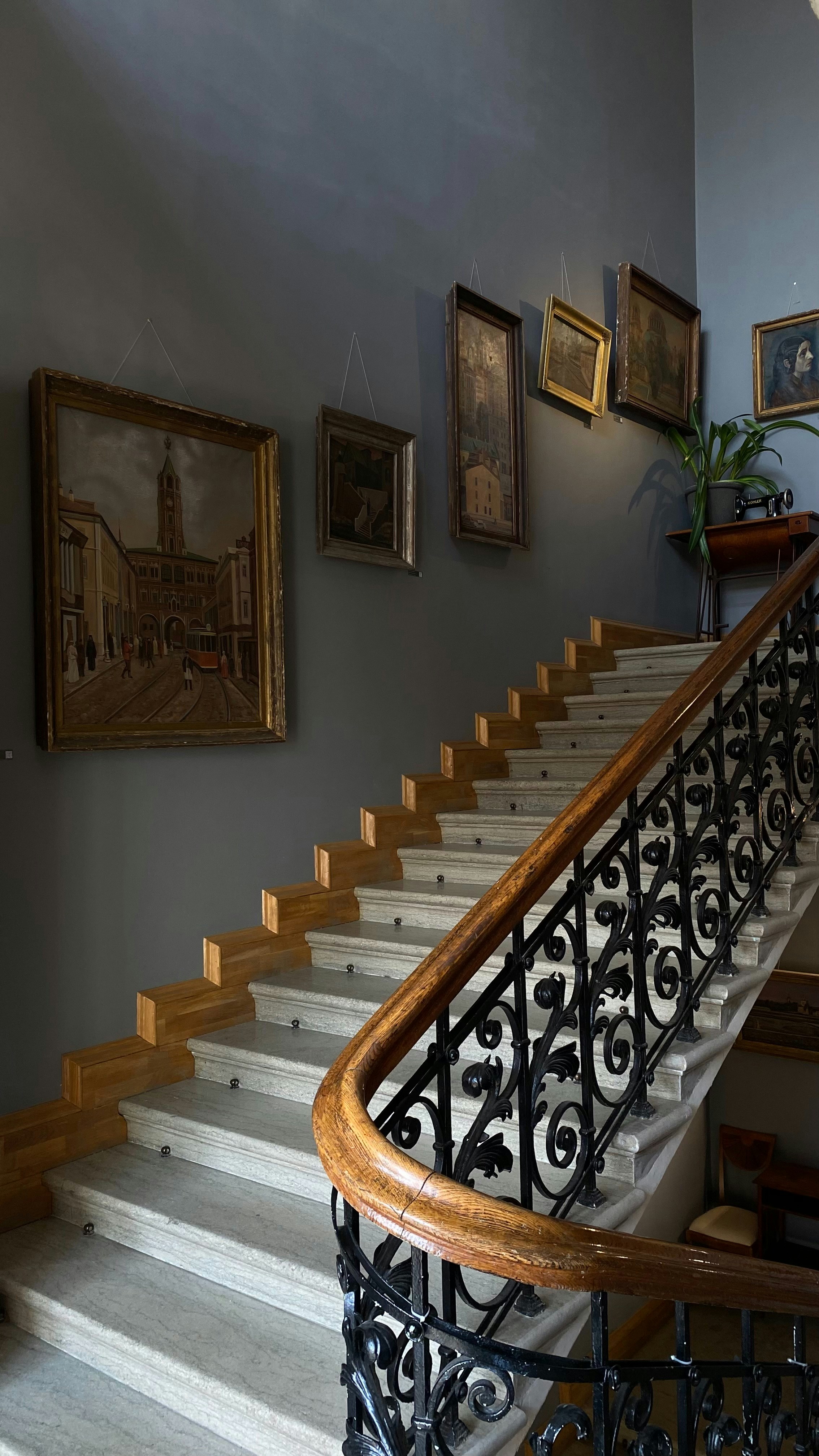 Grand staircase with ornate railing and artwork