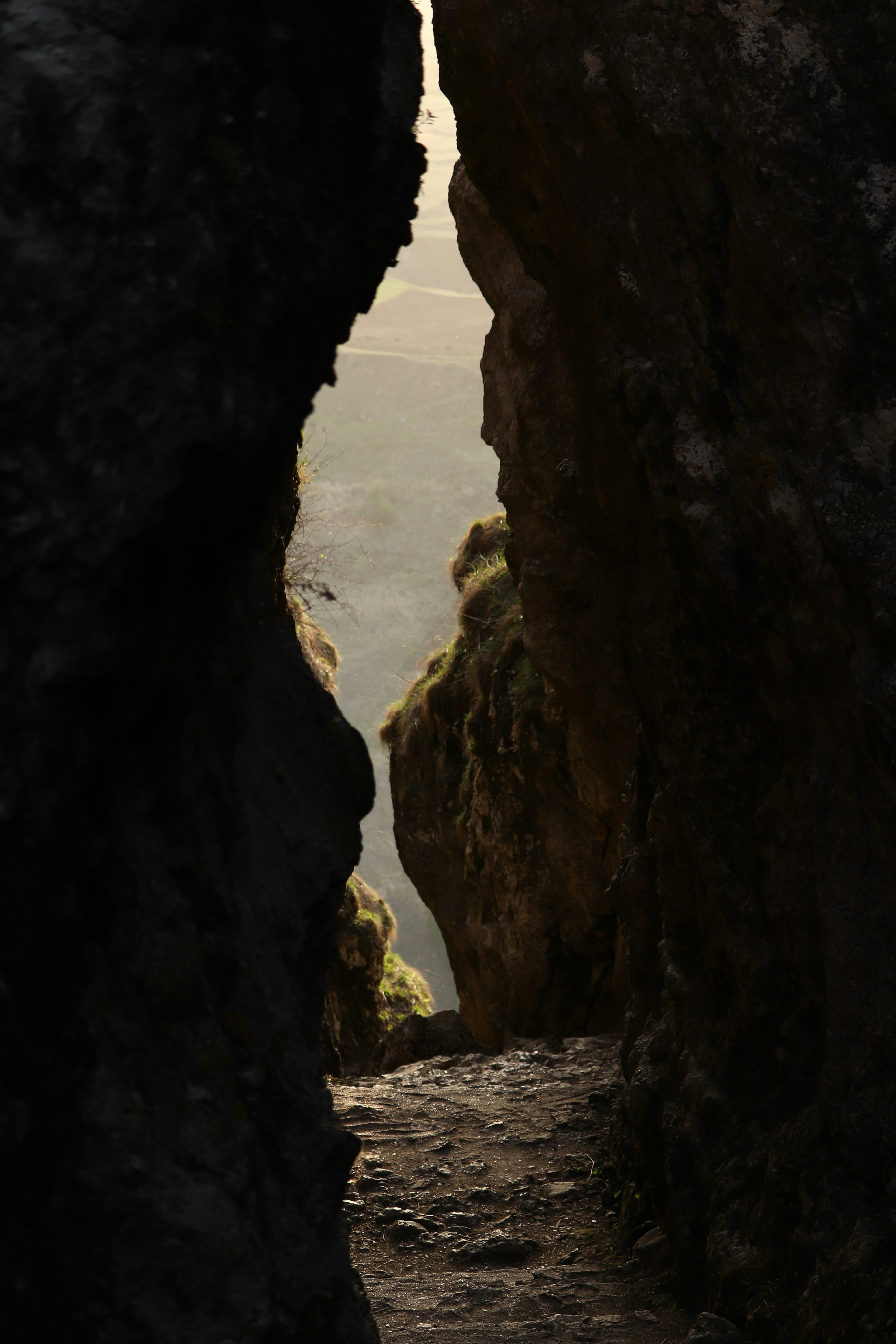 A narrow path between dark rocky cliffs.