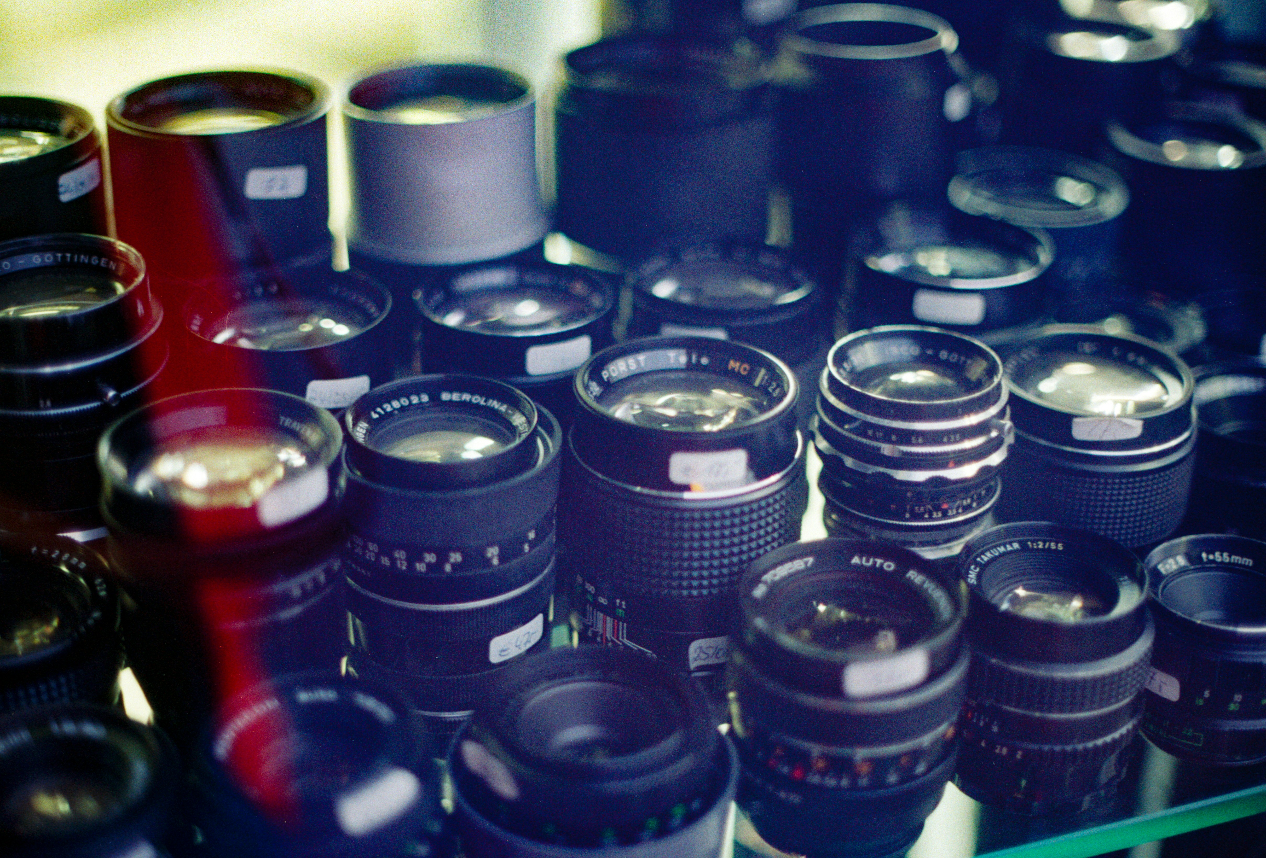 Collection of camera lenses displayed on a shelf. photo – Free ...