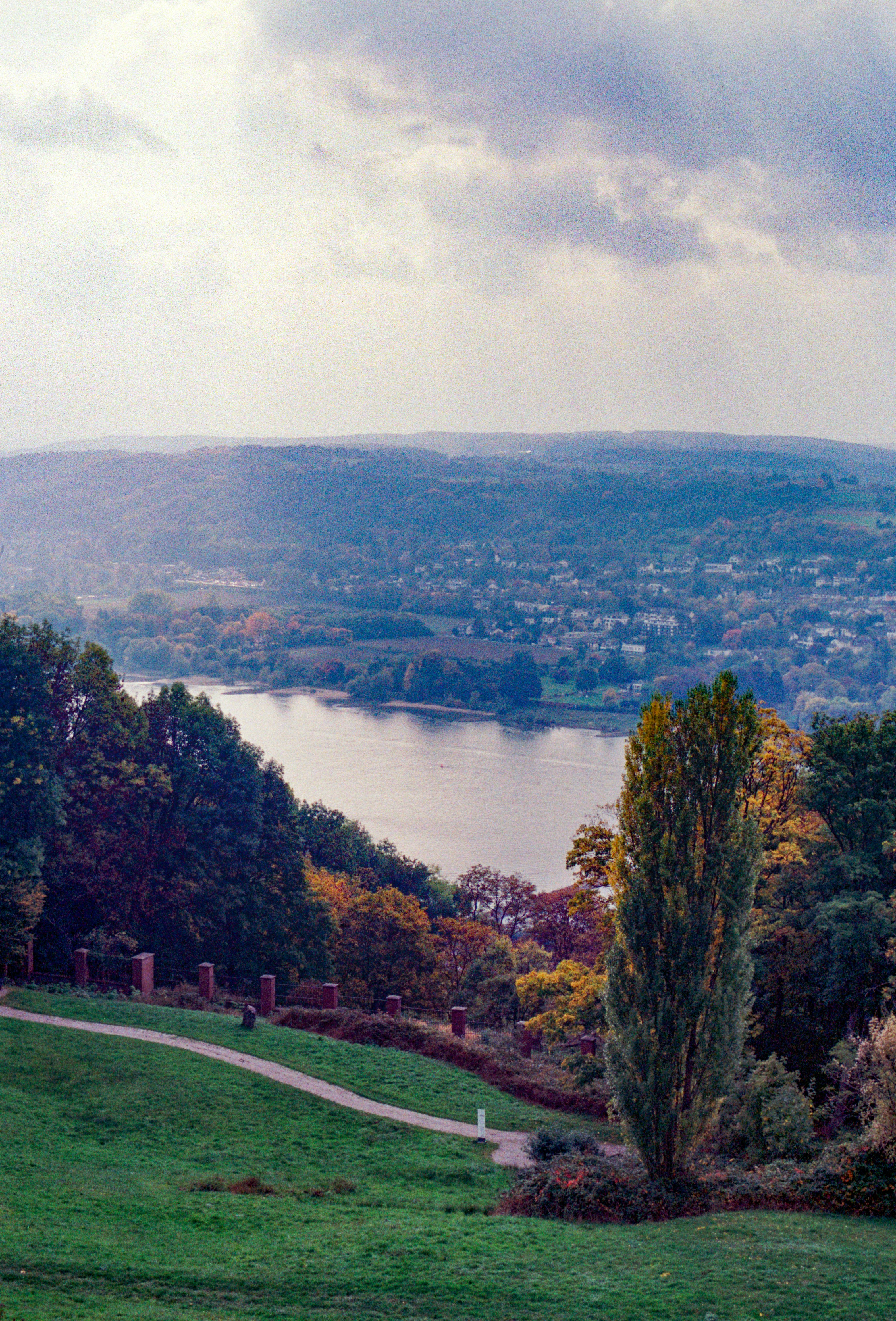 Hills covered in autumn trees overlook a calm lake.