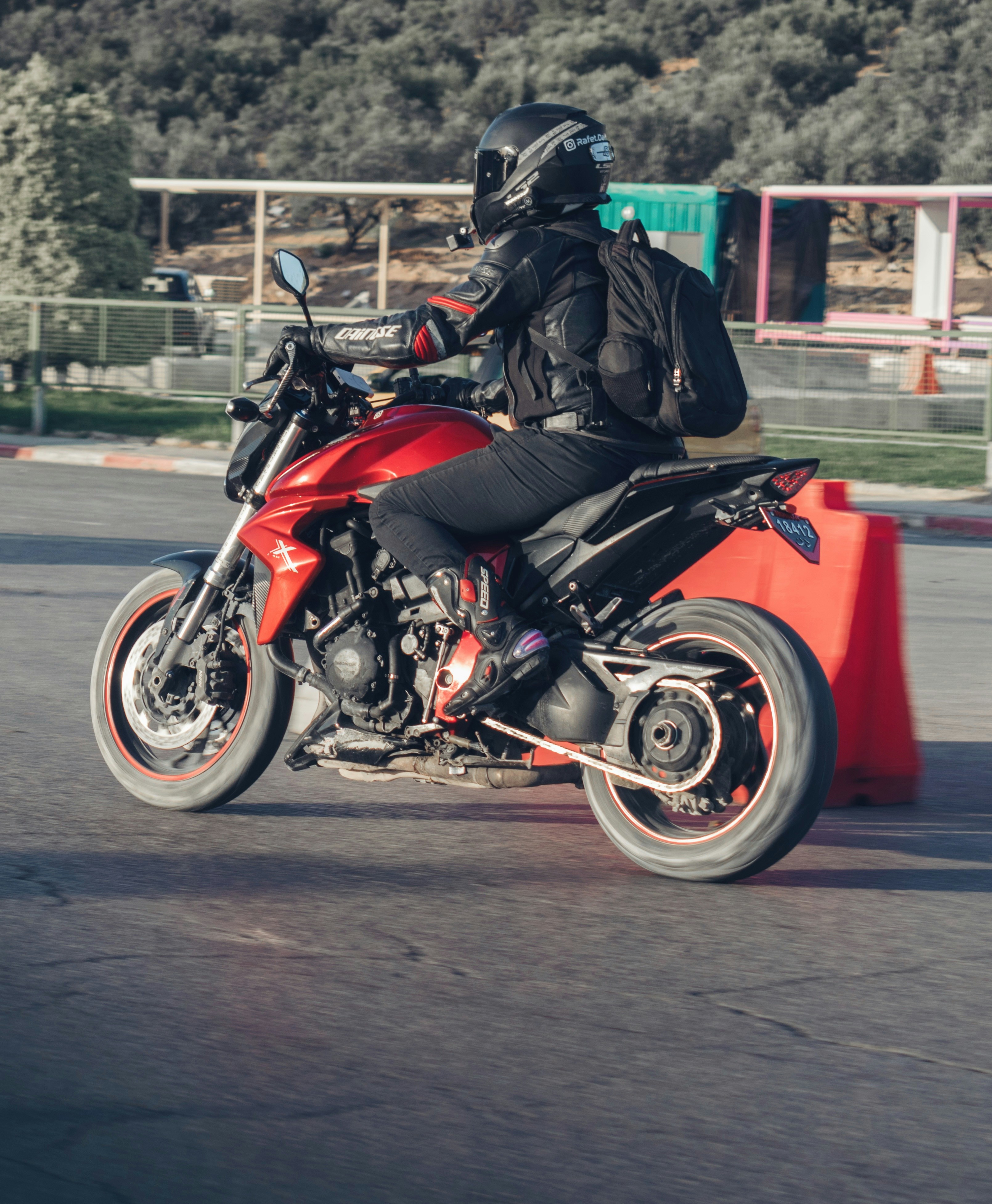 Person riding a red motorcycle on a road