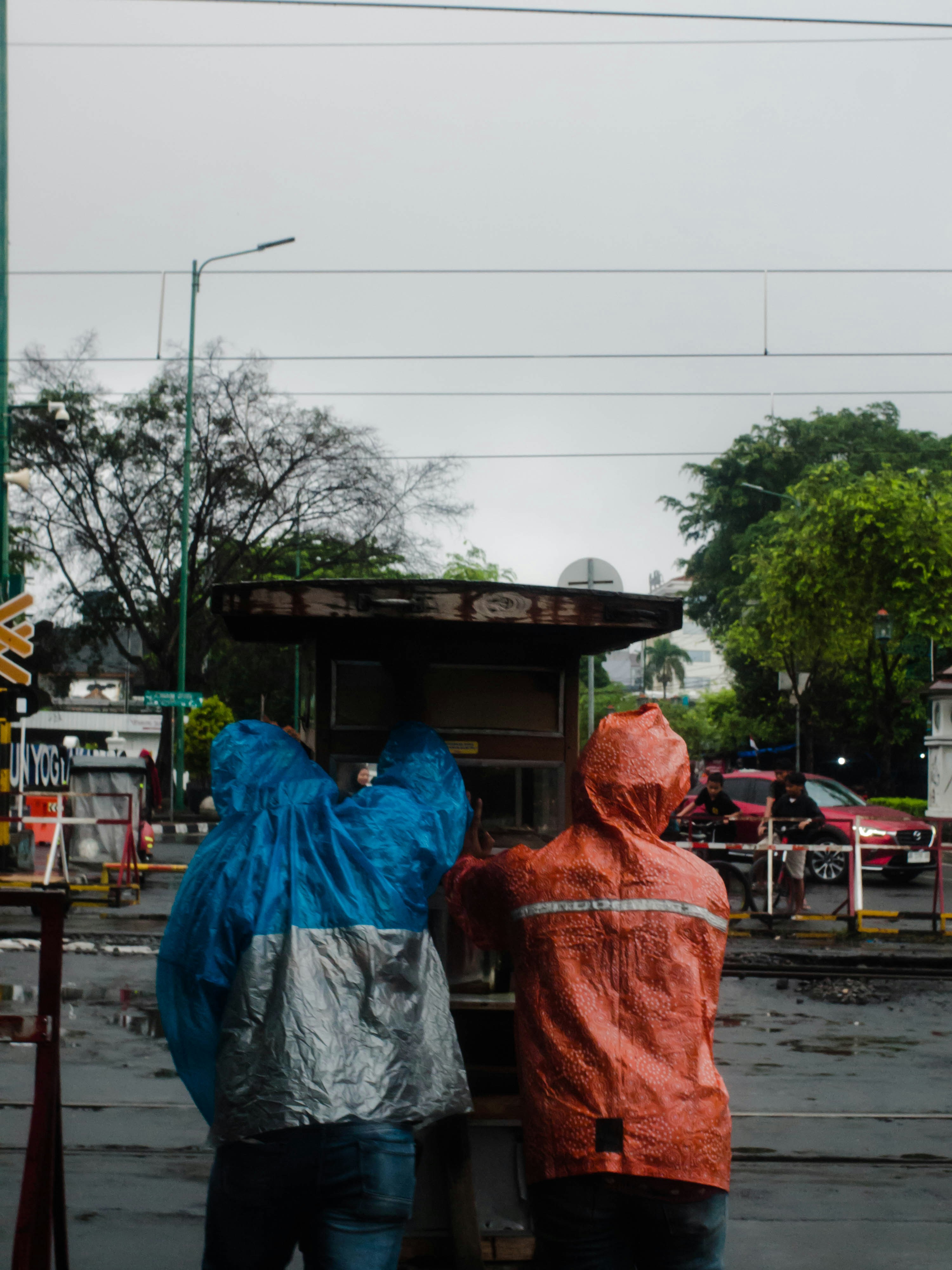 Color Sparks in the Rain: Blue and Orange Raincoats at a Street Vendor