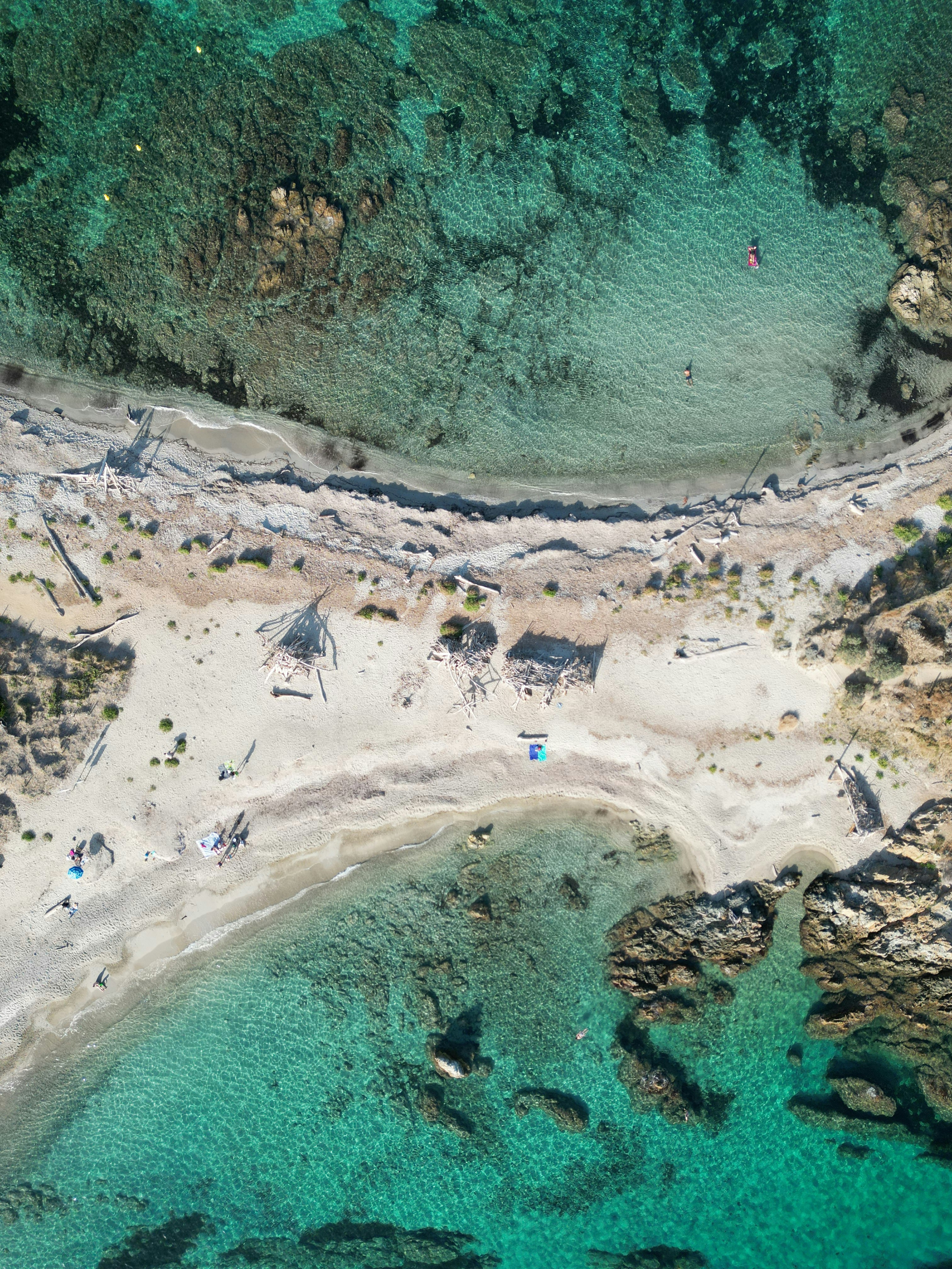 Aerial view of a sandy beach with clear turquoise water.