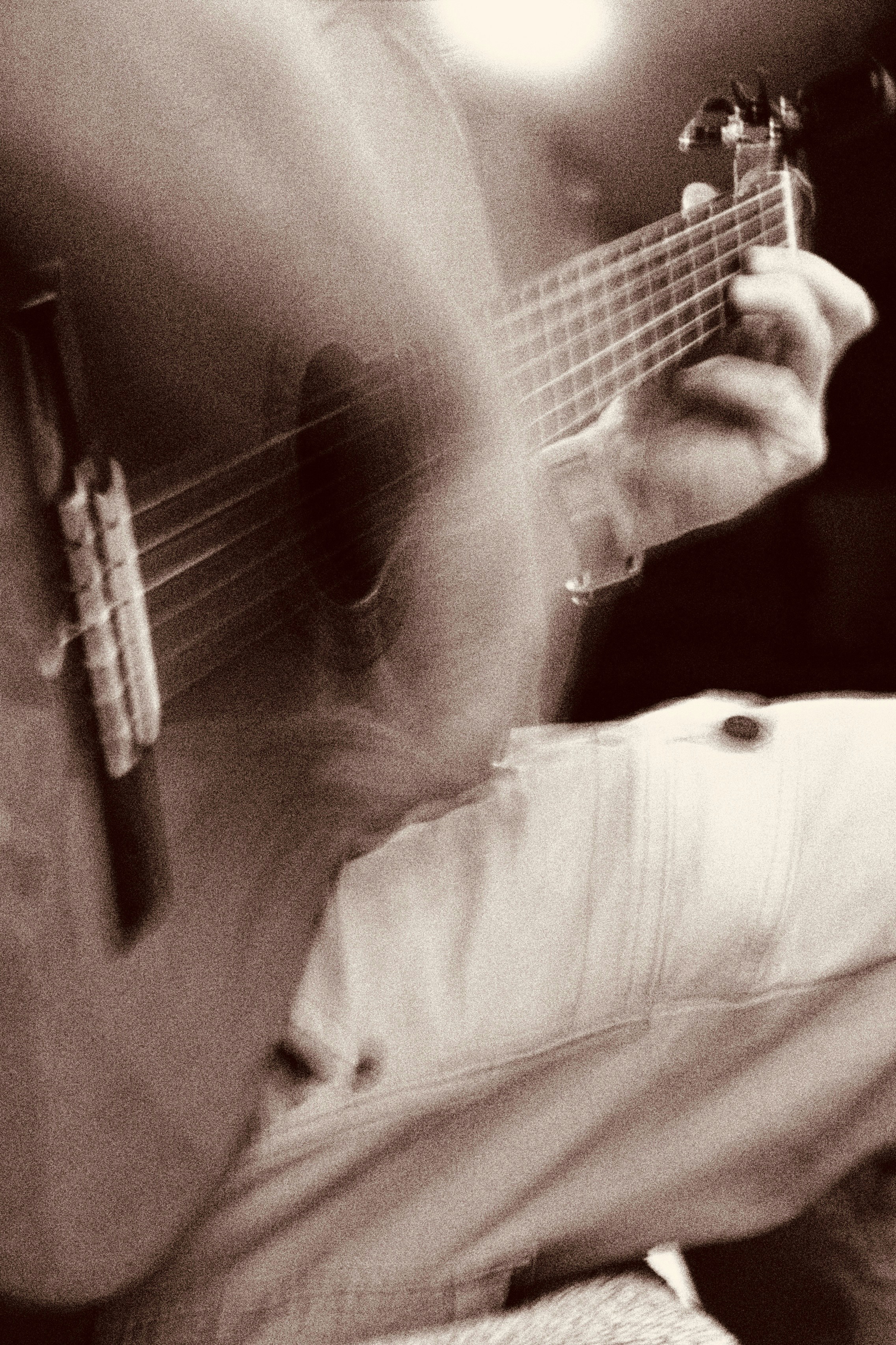 Fretboard Quiet: Sepia Close-Up of Strings and Fingers