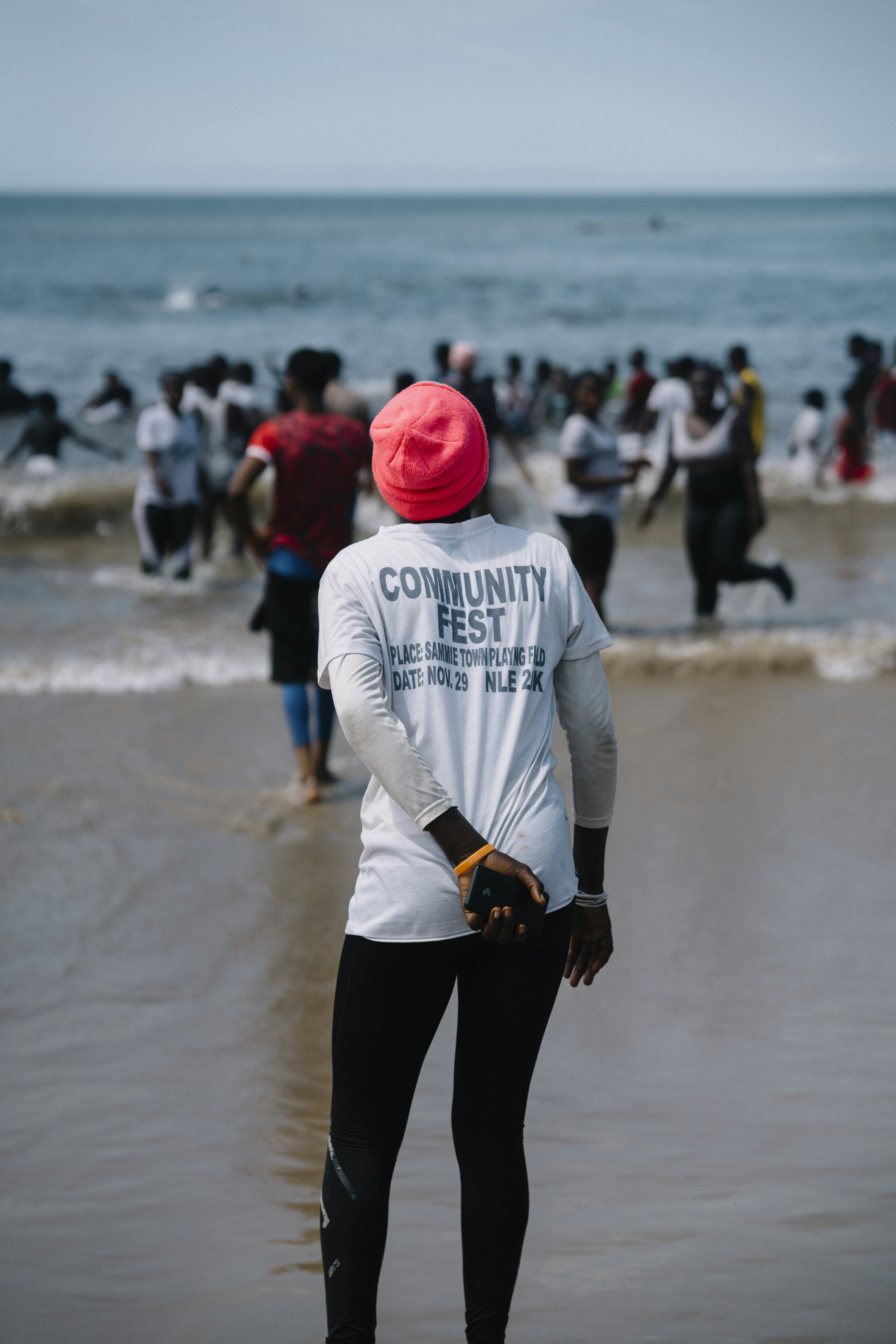 People gathered at a beach with waves crashing.