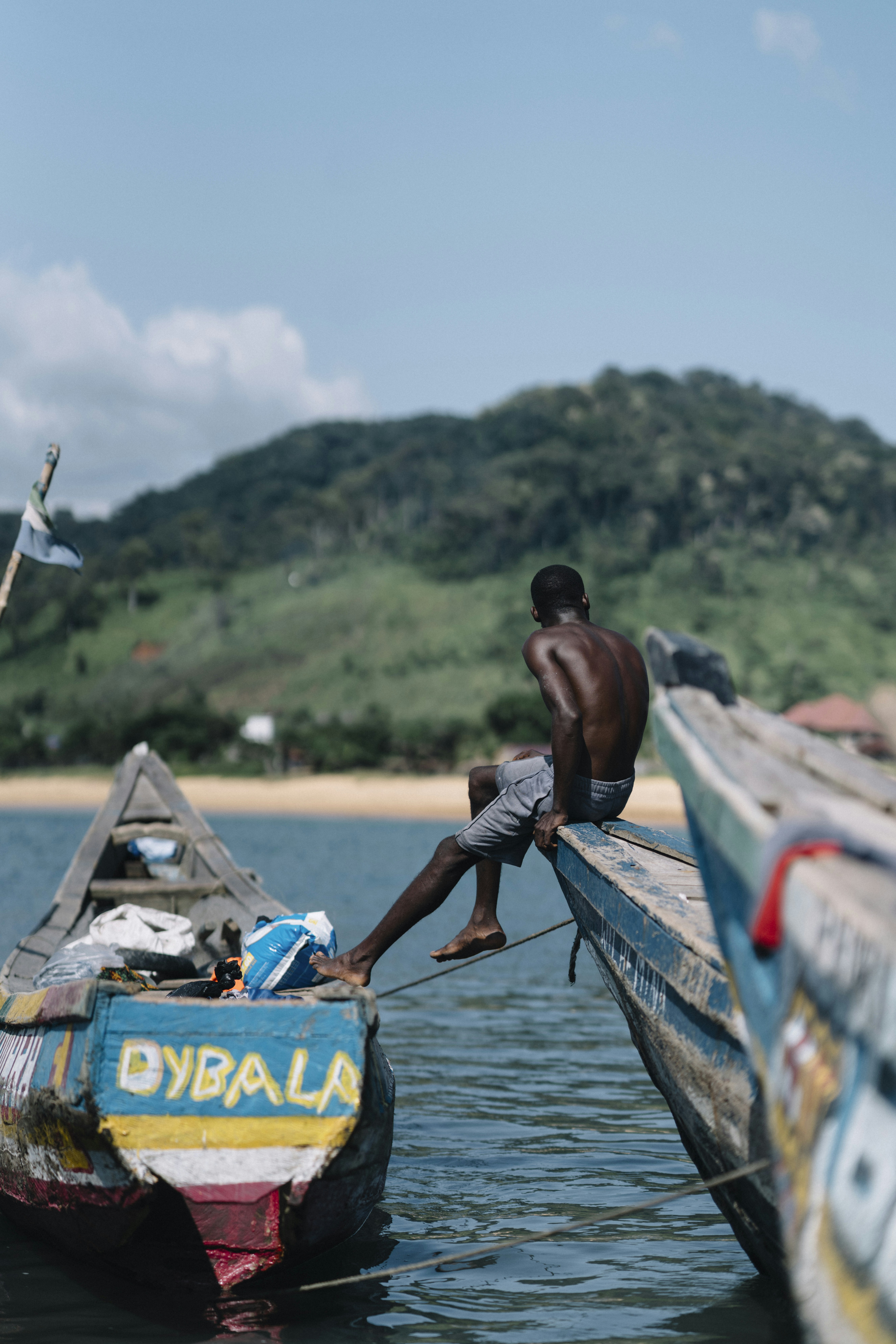 Bowline Stillness: A Man Perched on a Weathered Boat