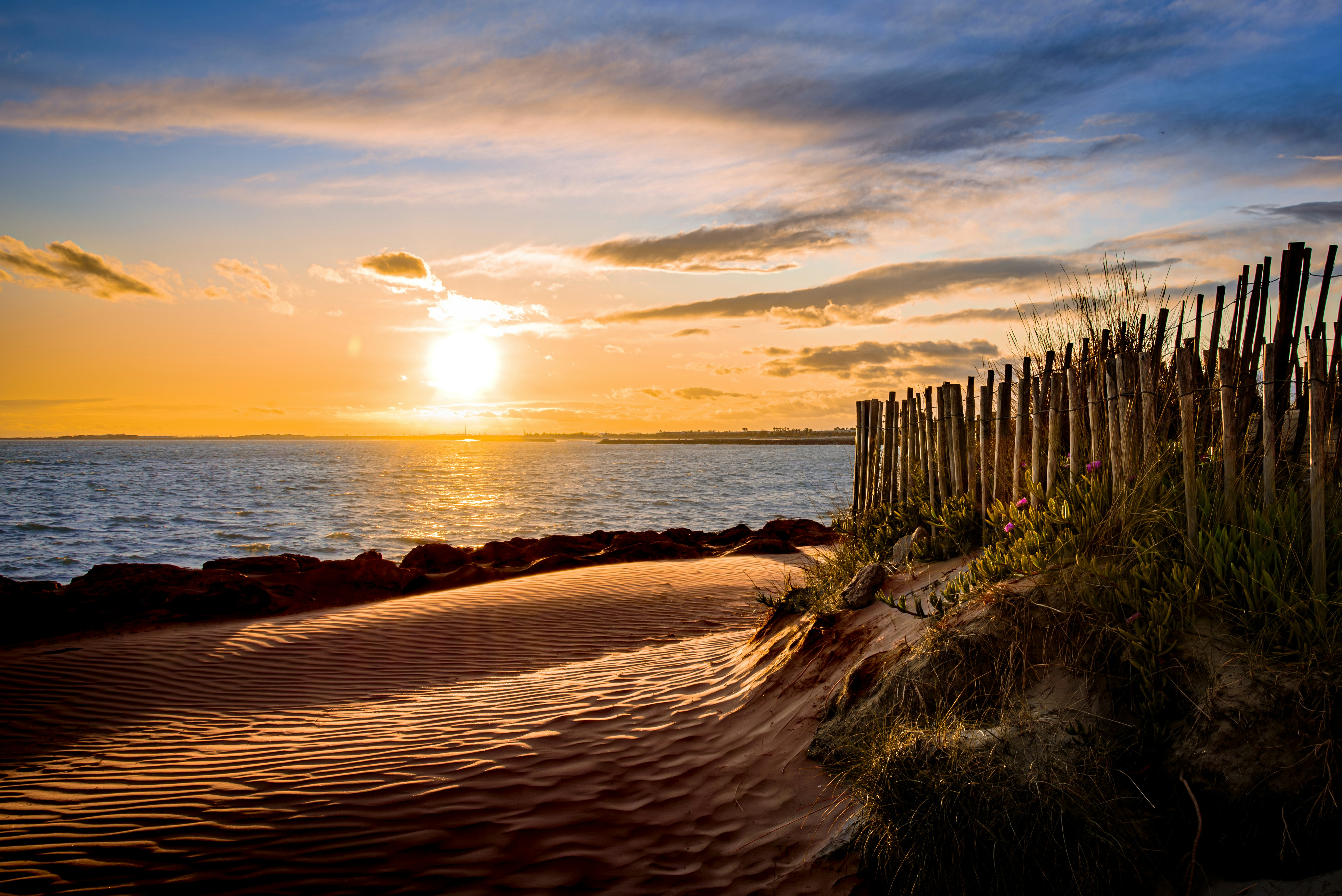 Sunlit Dunes and Weathered Fences at Dusk