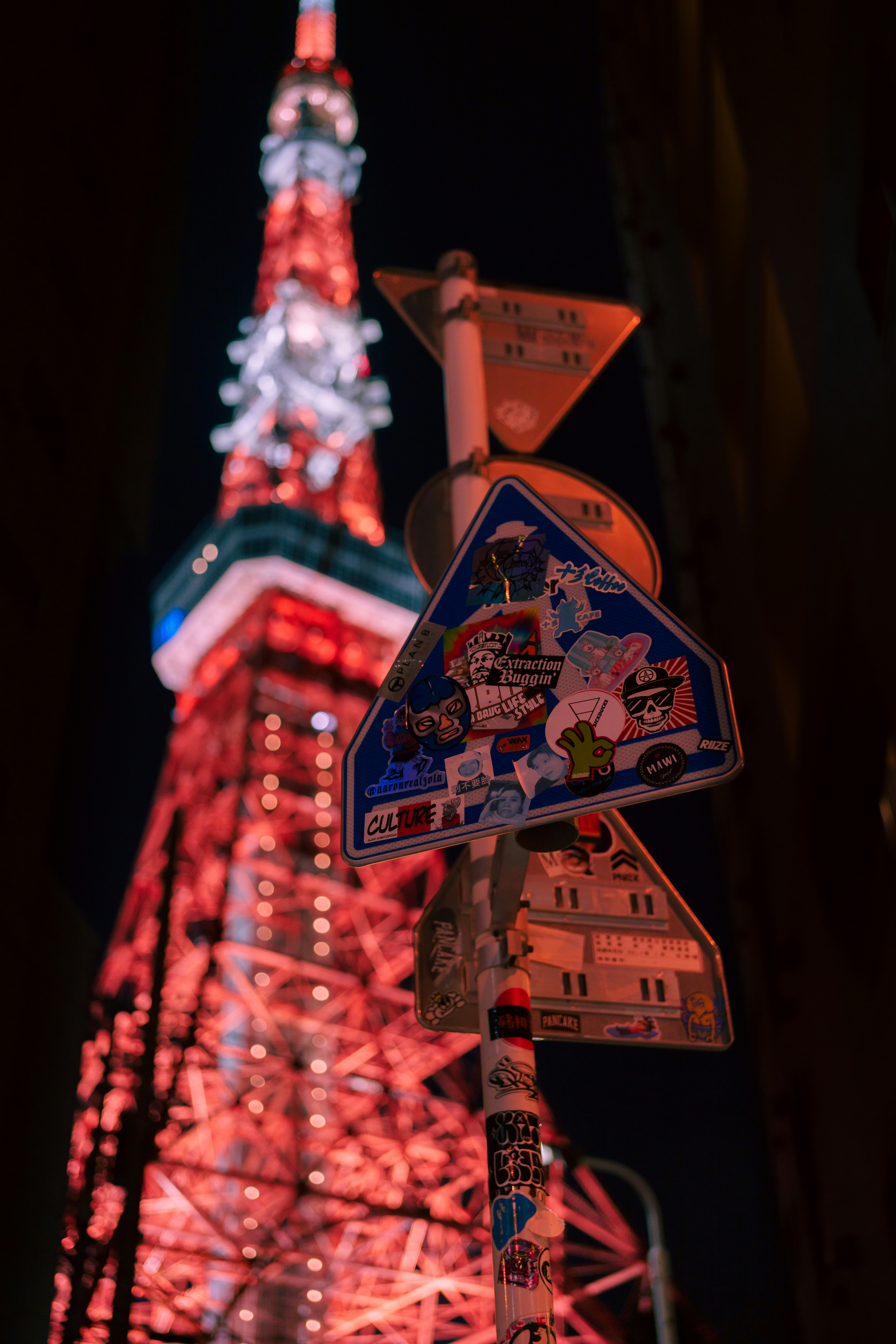 Tokyo tower illuminated at night with street signs