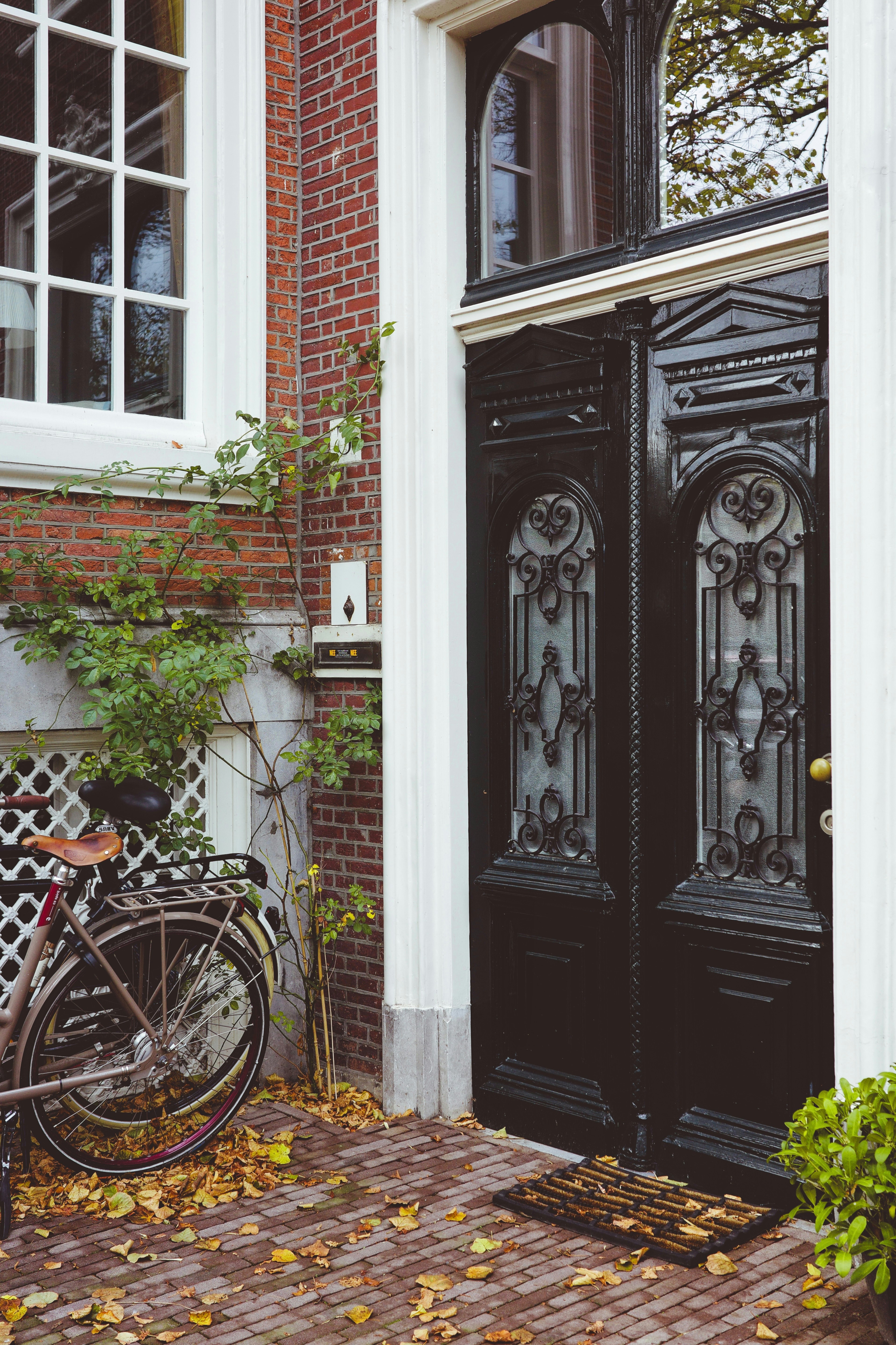 A vintage bicycle parked by a brick building entrance.