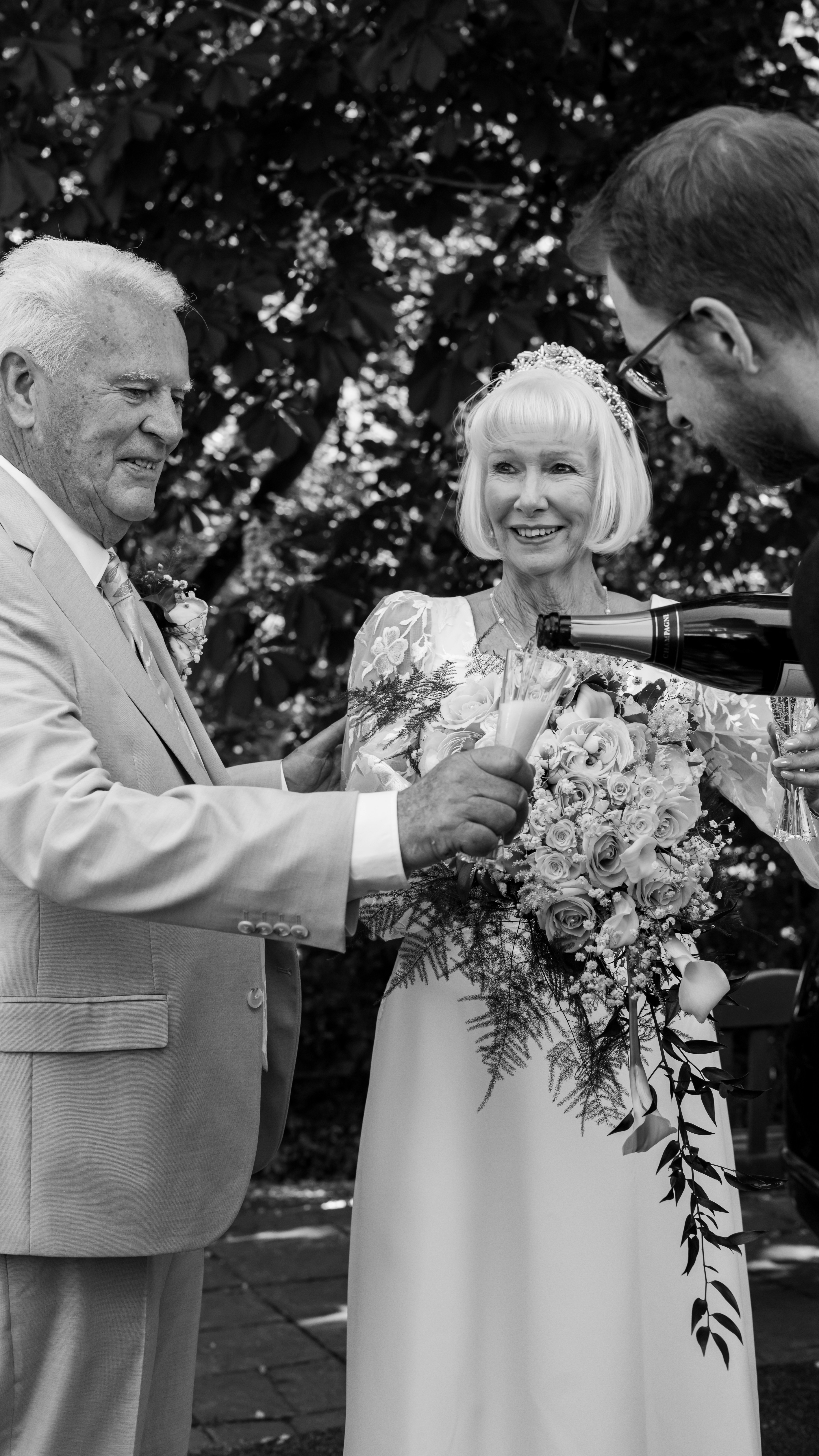 A joyful couple celebrating their union, surrounded by floral arrangements and laughter. The moment captures the essence of a wedding toast.