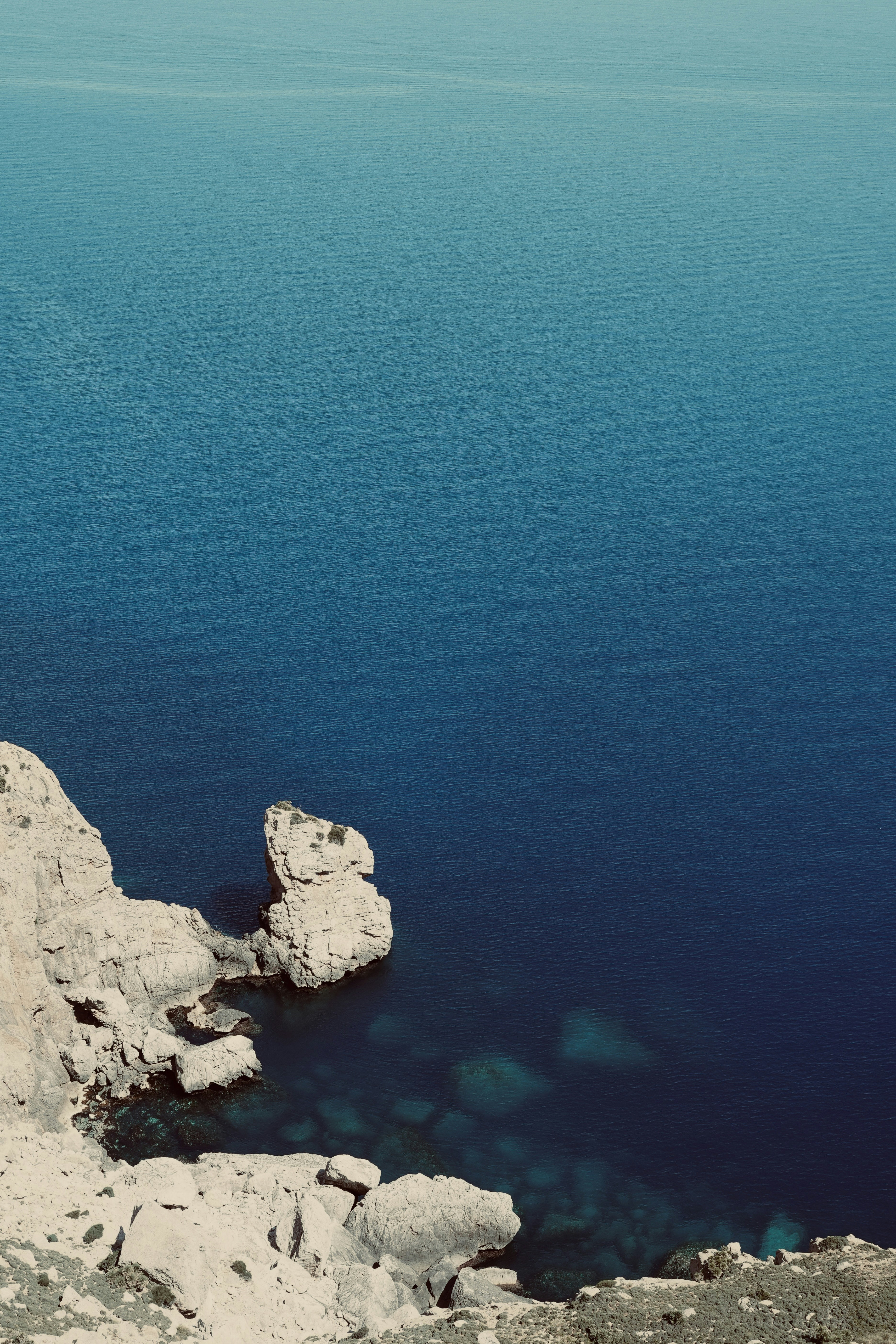 Rocky coastline meets the deep blue ocean water