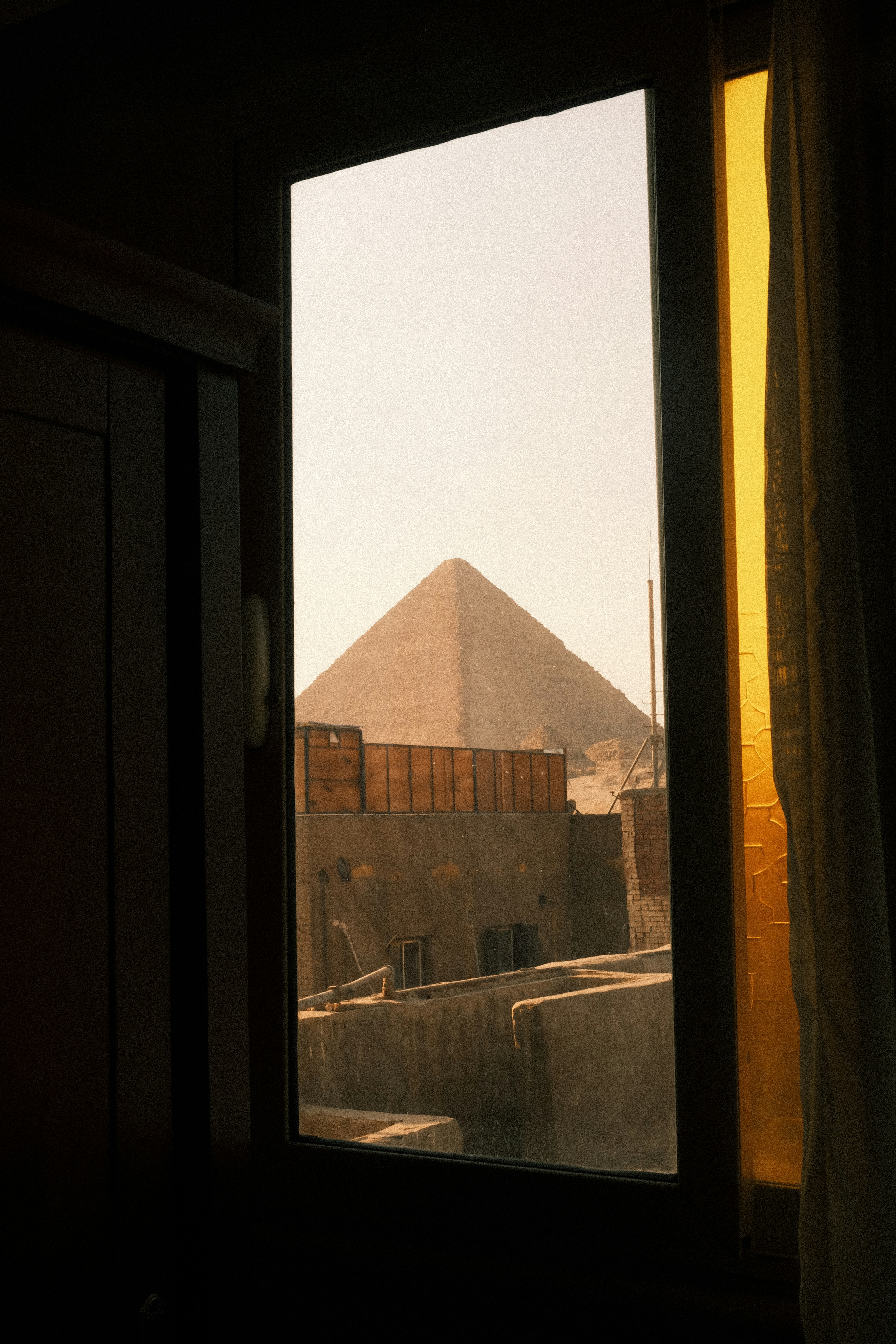 hotel window overlooking the giza pyramids | Great pyramid of giza seen through a window.