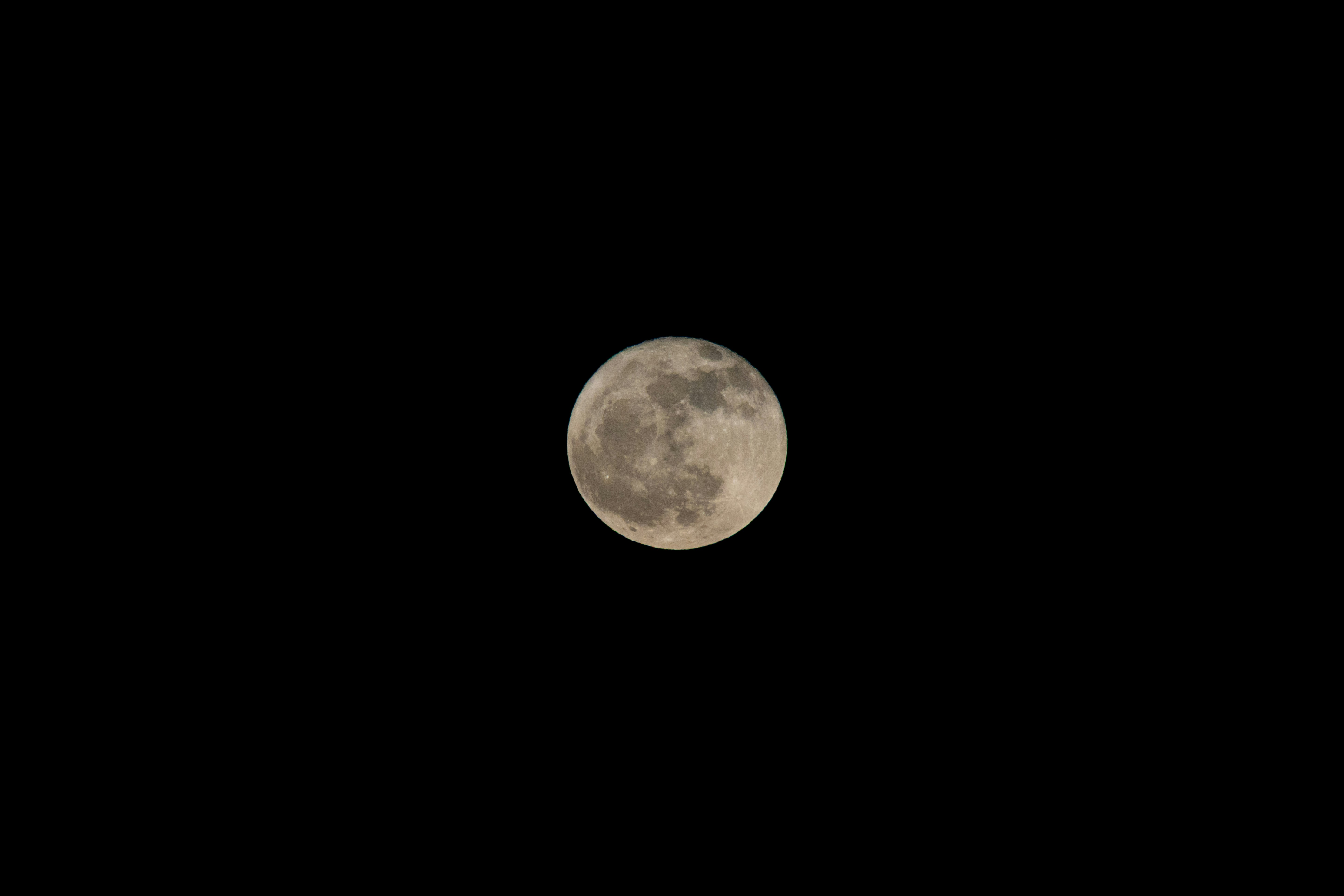 Full moon shining brightly in the dark night sky