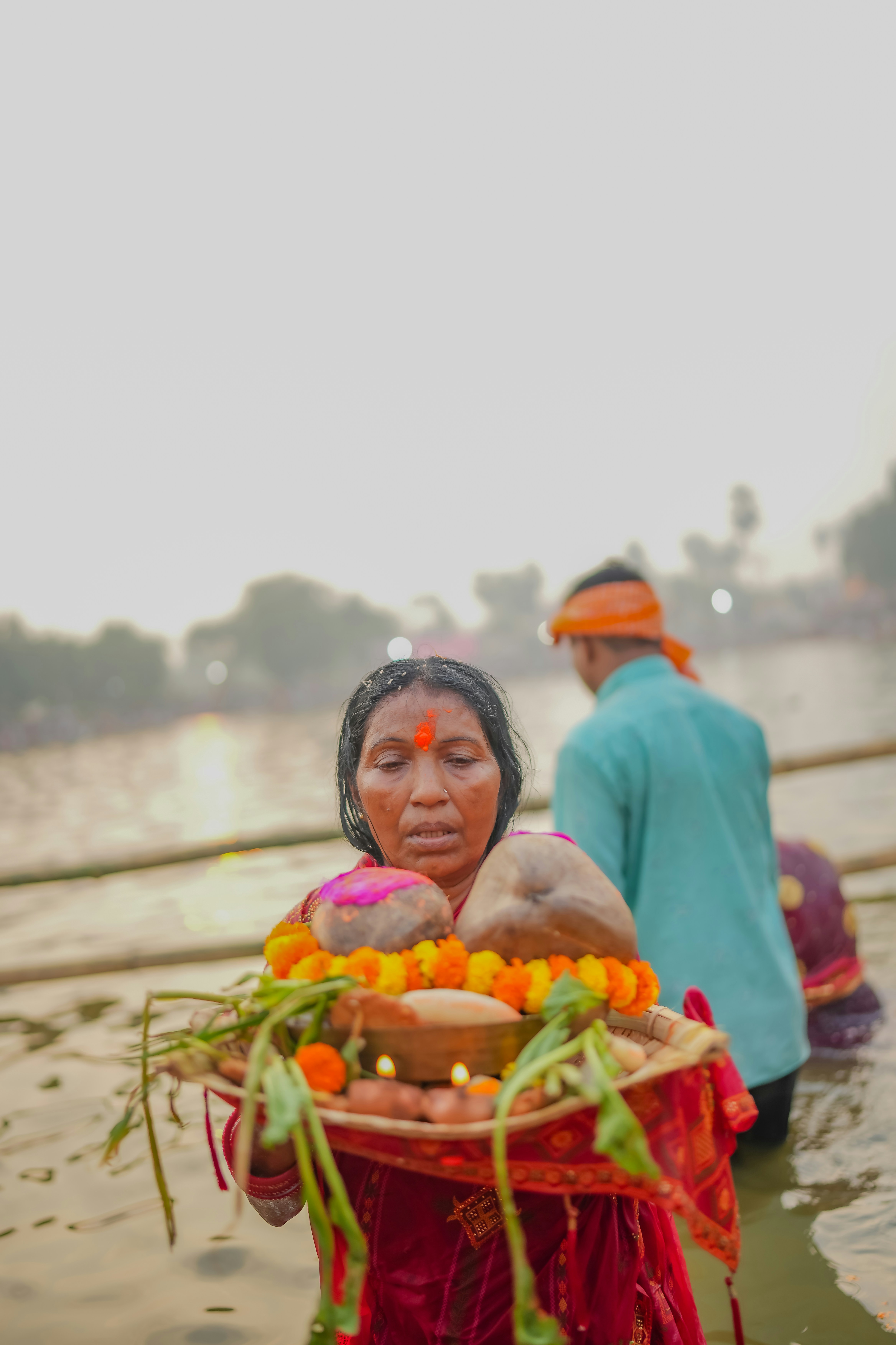 Dawn Riverside Offering: A Woman in Red Carries Sacred Coconuts