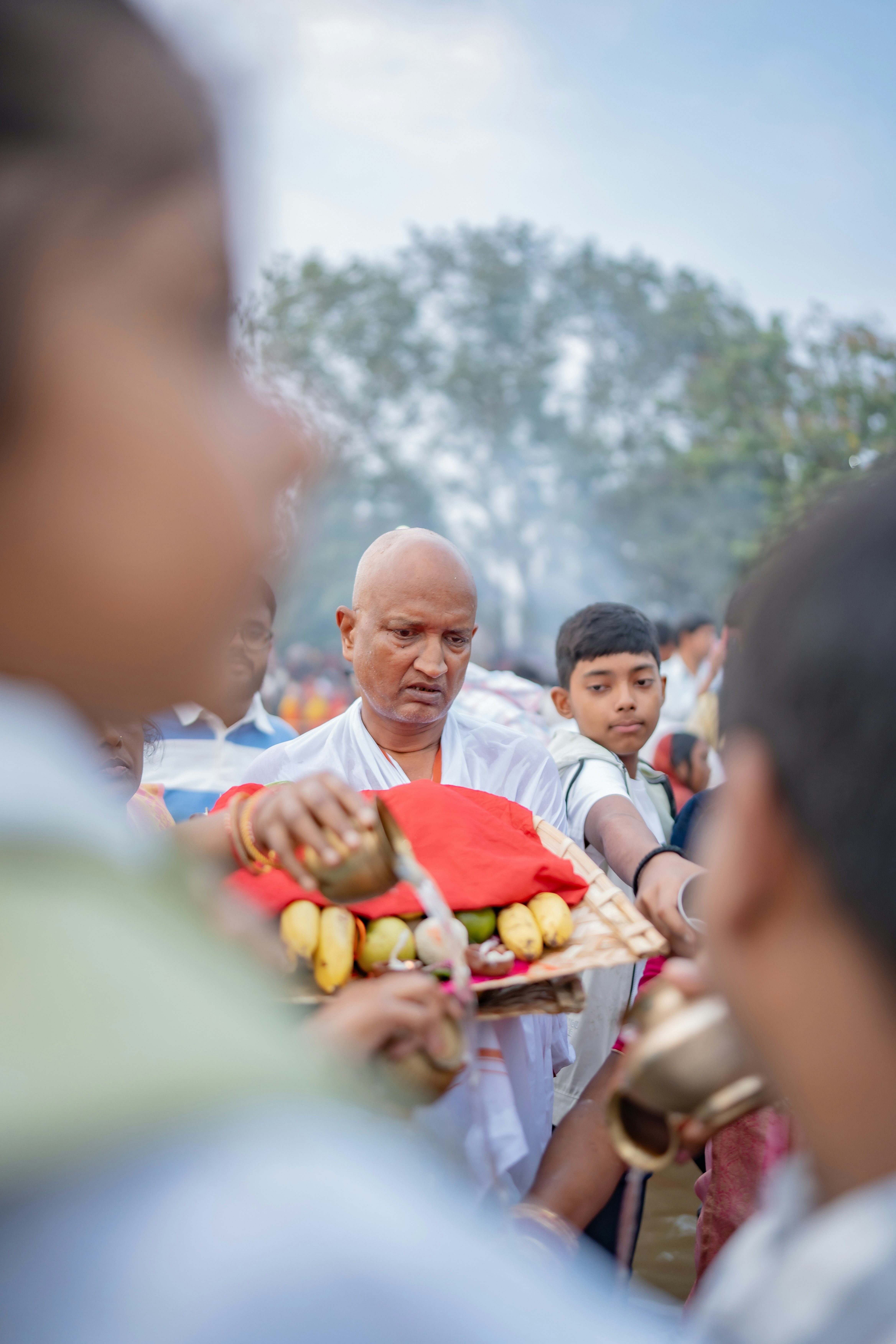 Chhath Mahaparva ❤️🙏 One of my favorite festivals, because it's so full of emotions. | Man holding offerings of fruit and cloth outdoors.