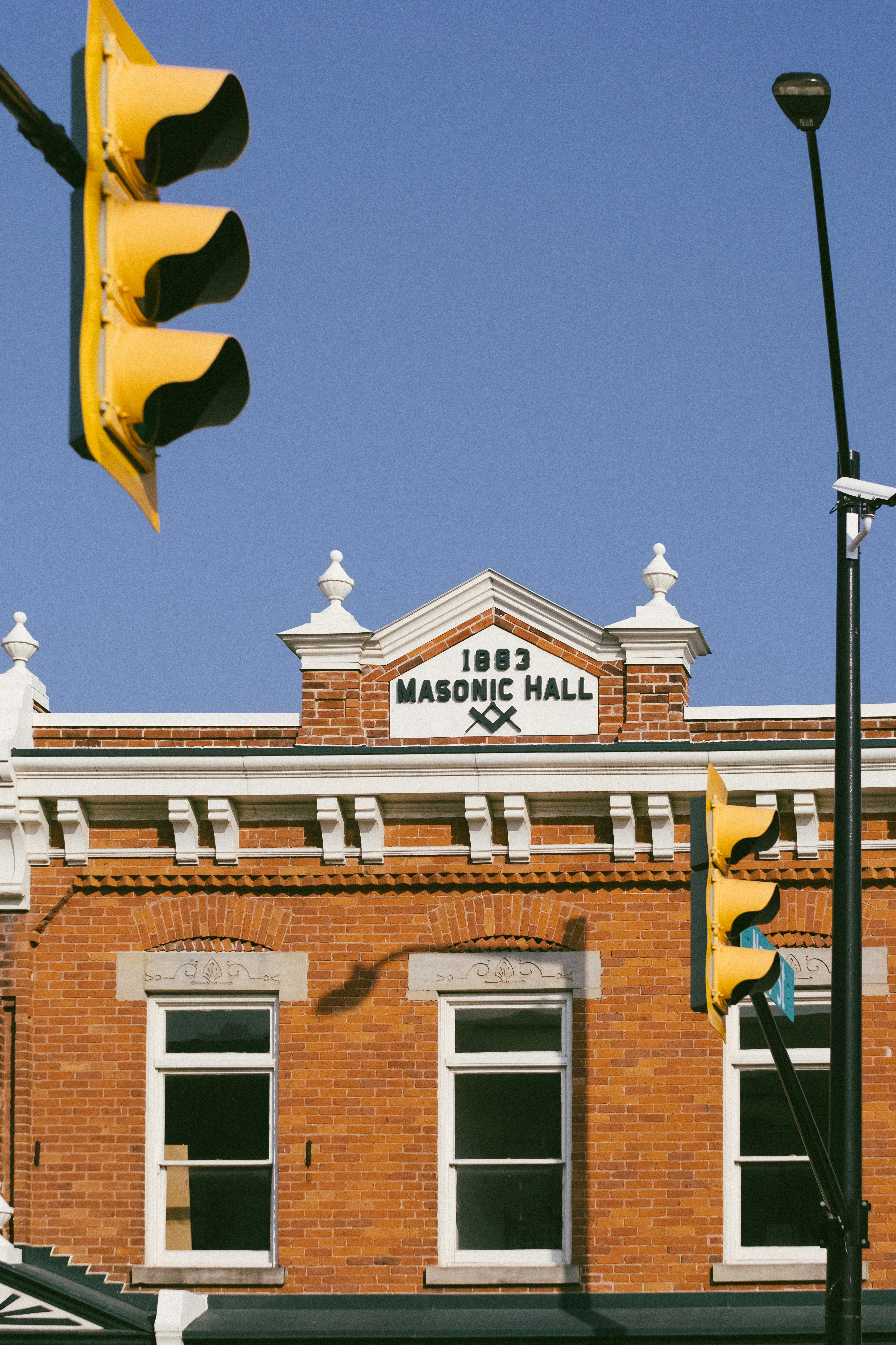 Masonic hall building with traffic lights and blue sky