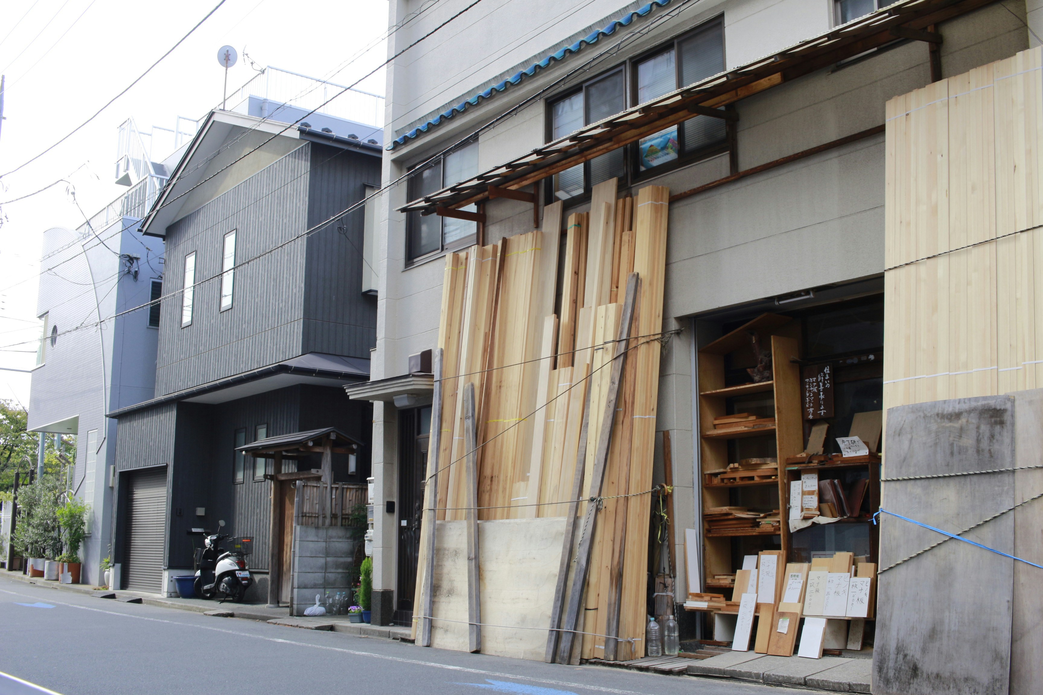 Stacks of lumber outside a building on a street.