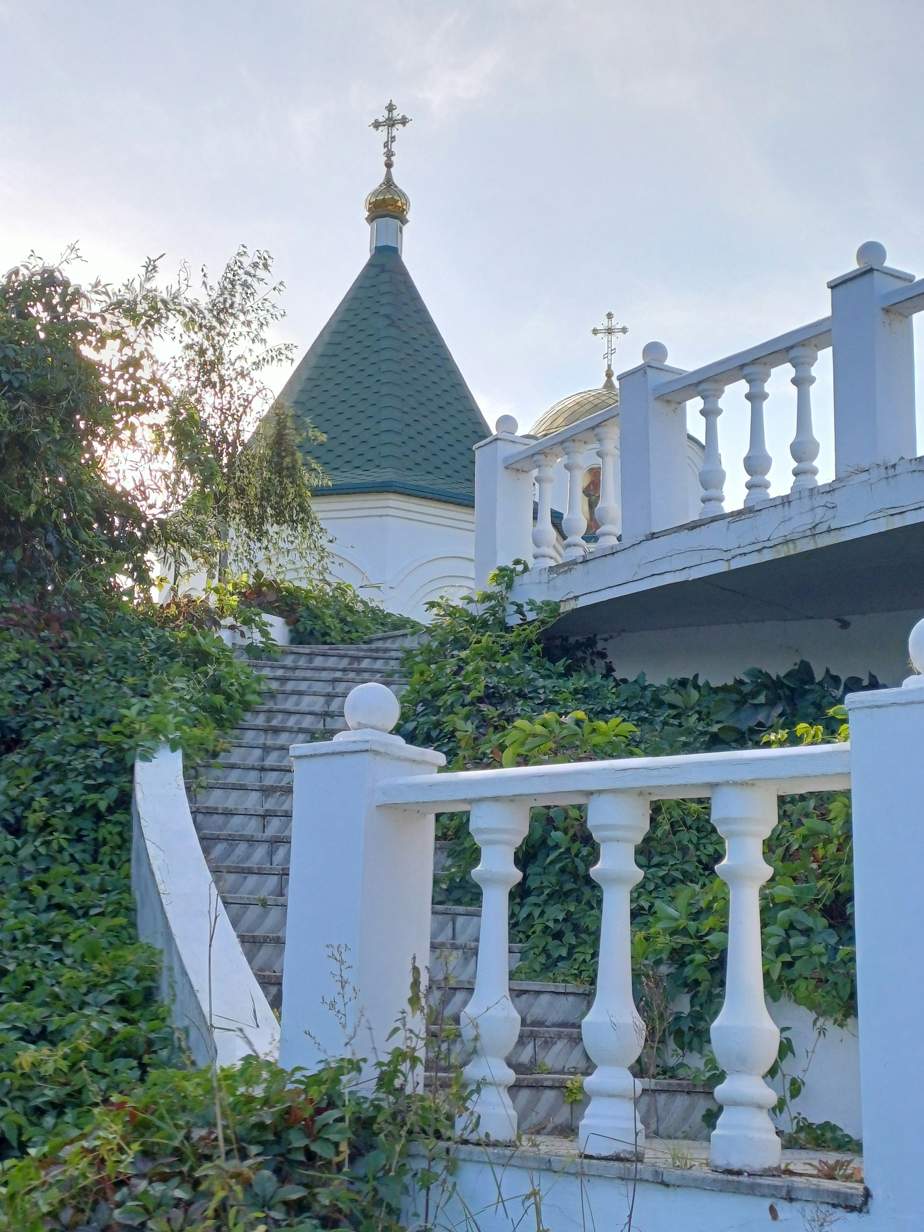 White building with green roof and crosses
