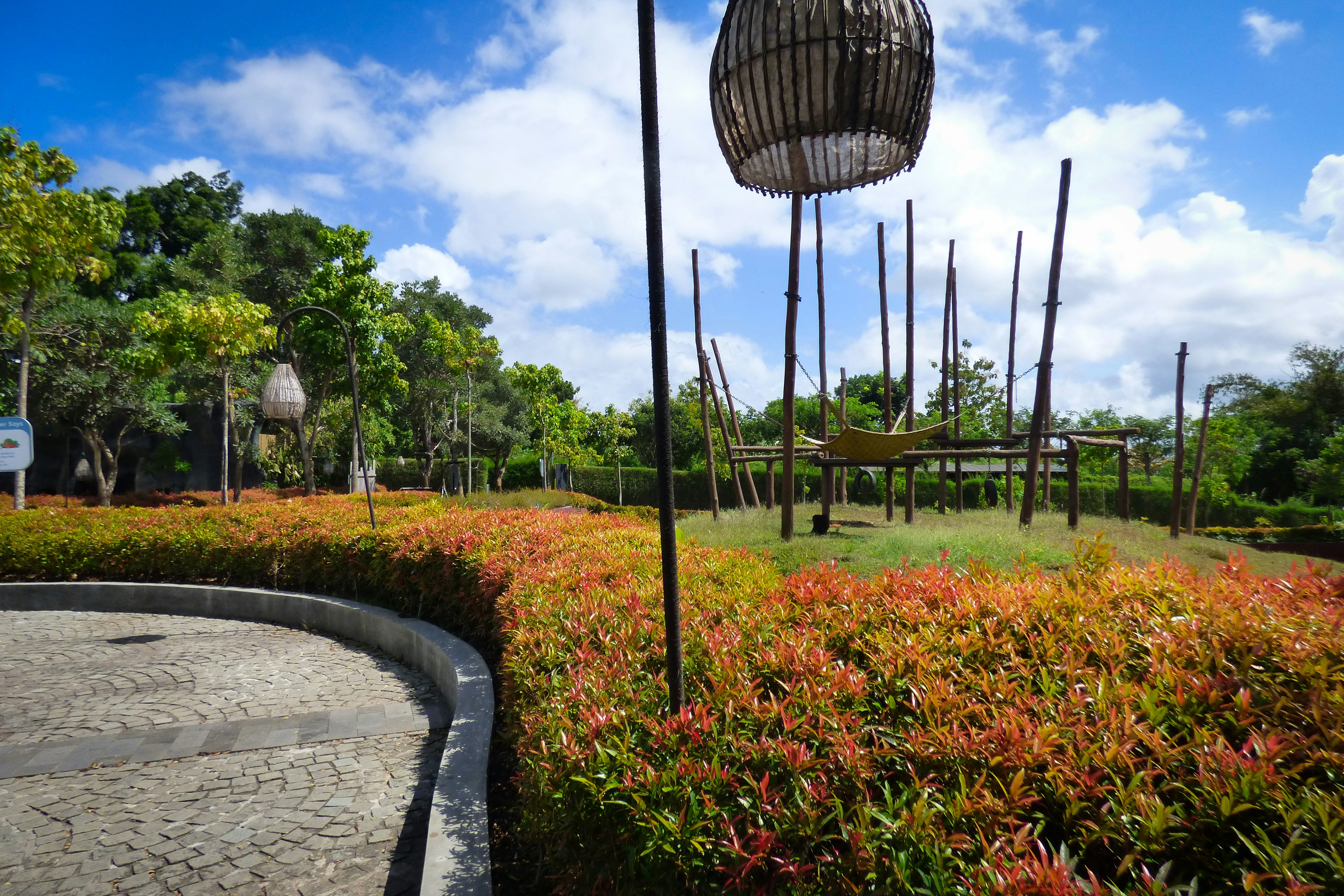 Lush garden with exotic plants and bamboo structures.