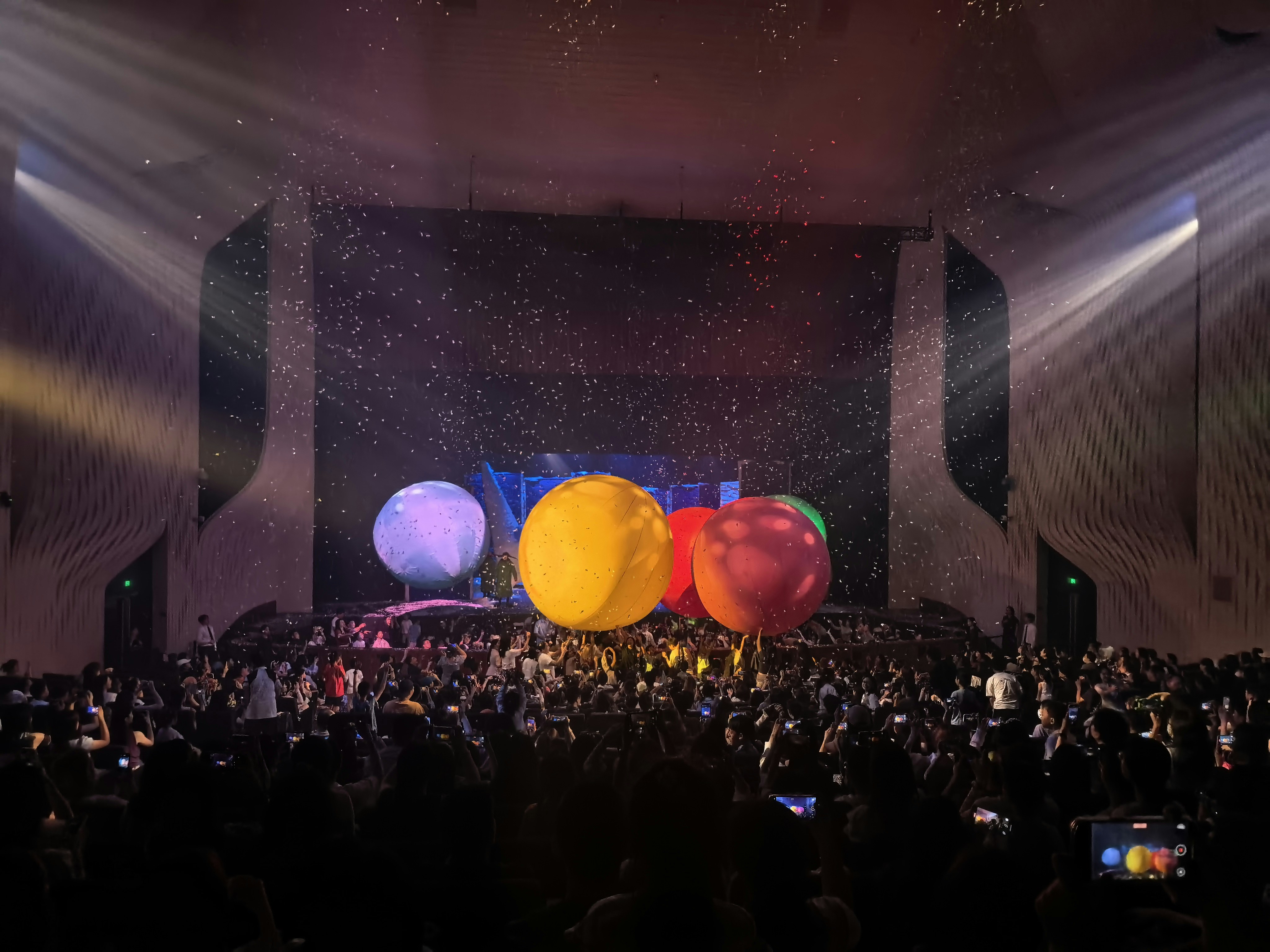 Orbital Glow: Giant Color Spheres Dominate a Packed Night Concert.