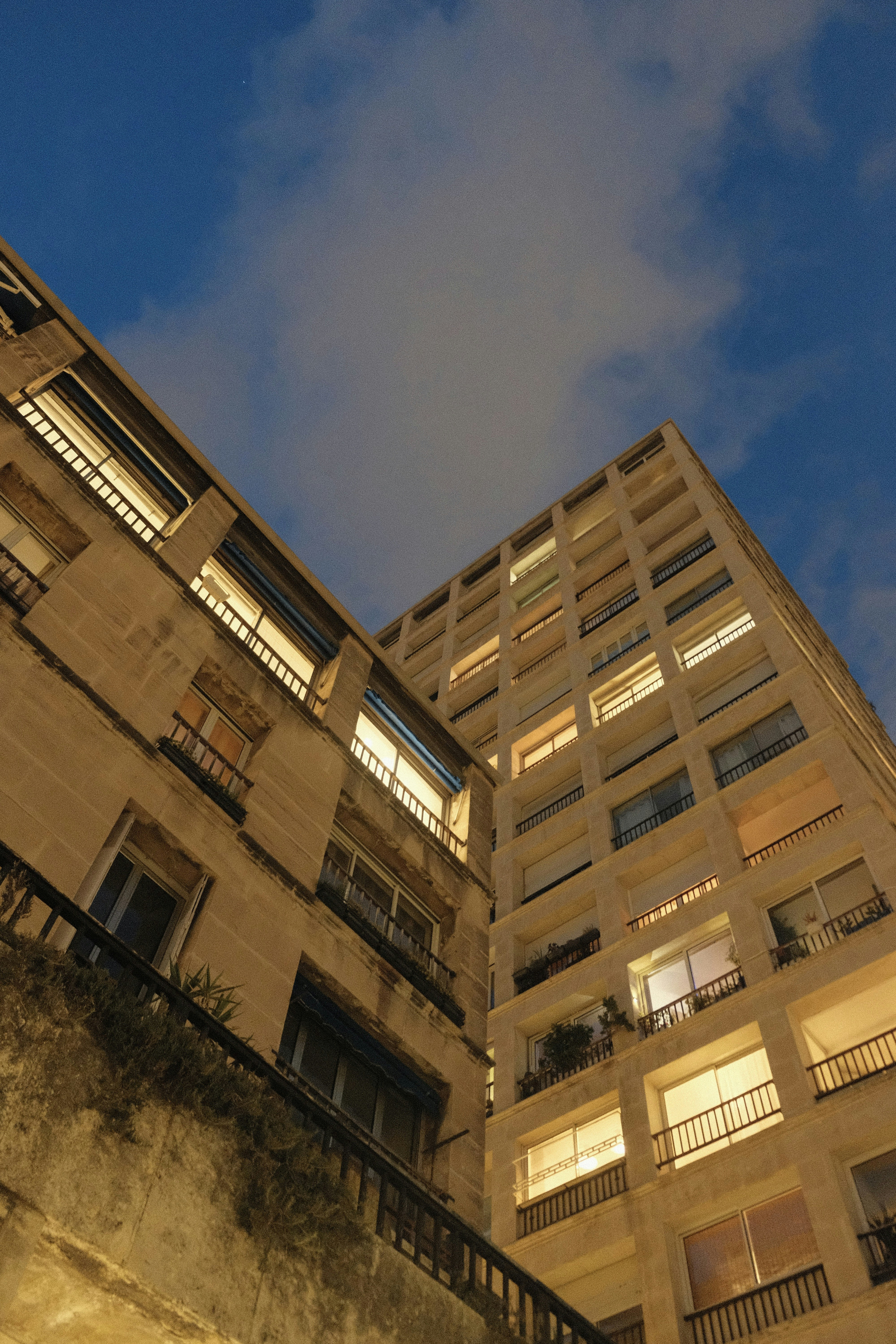 Apartment buildings at dusk with illuminated windows