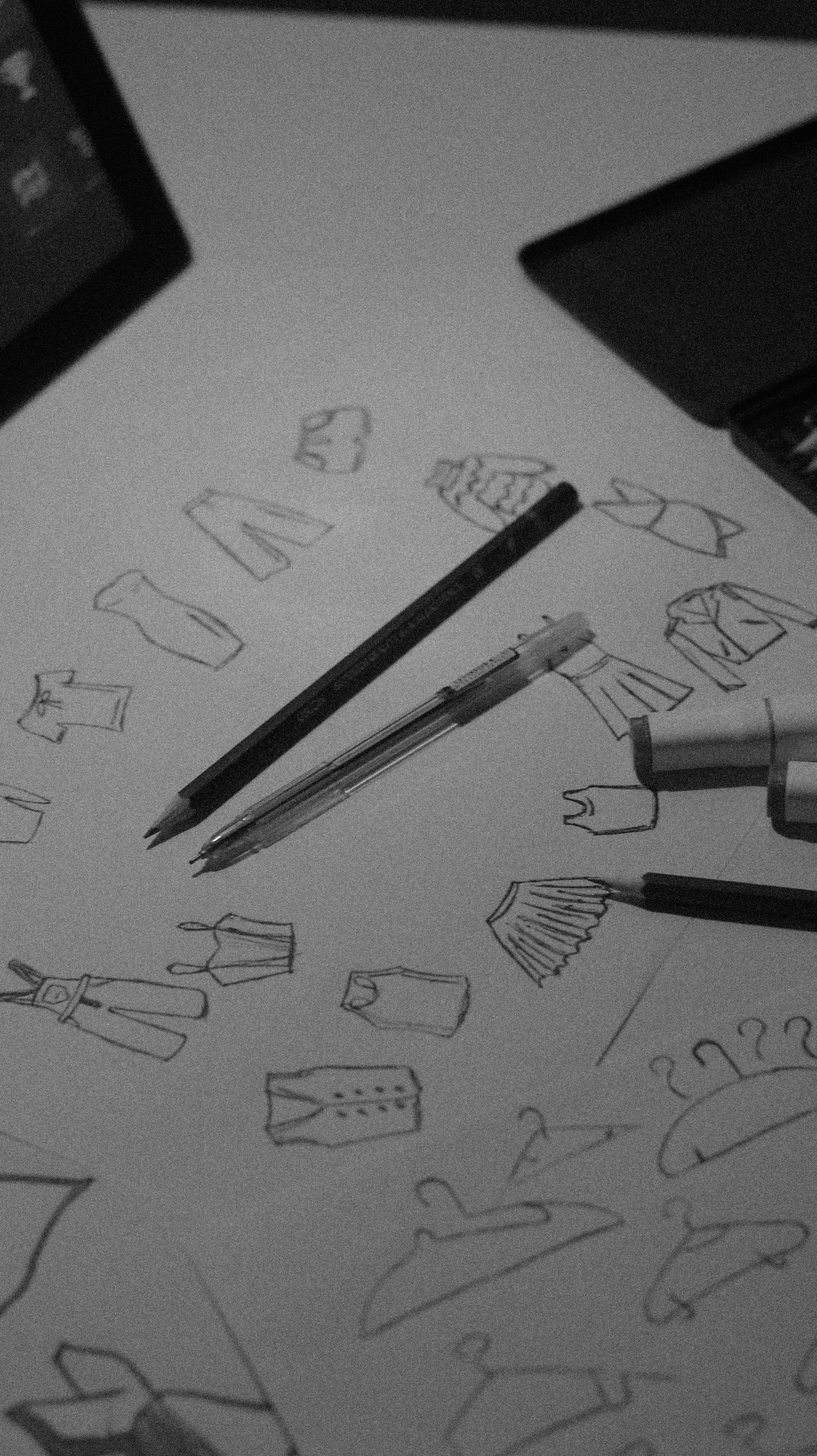 Sketches of clothing and hangers with pens.