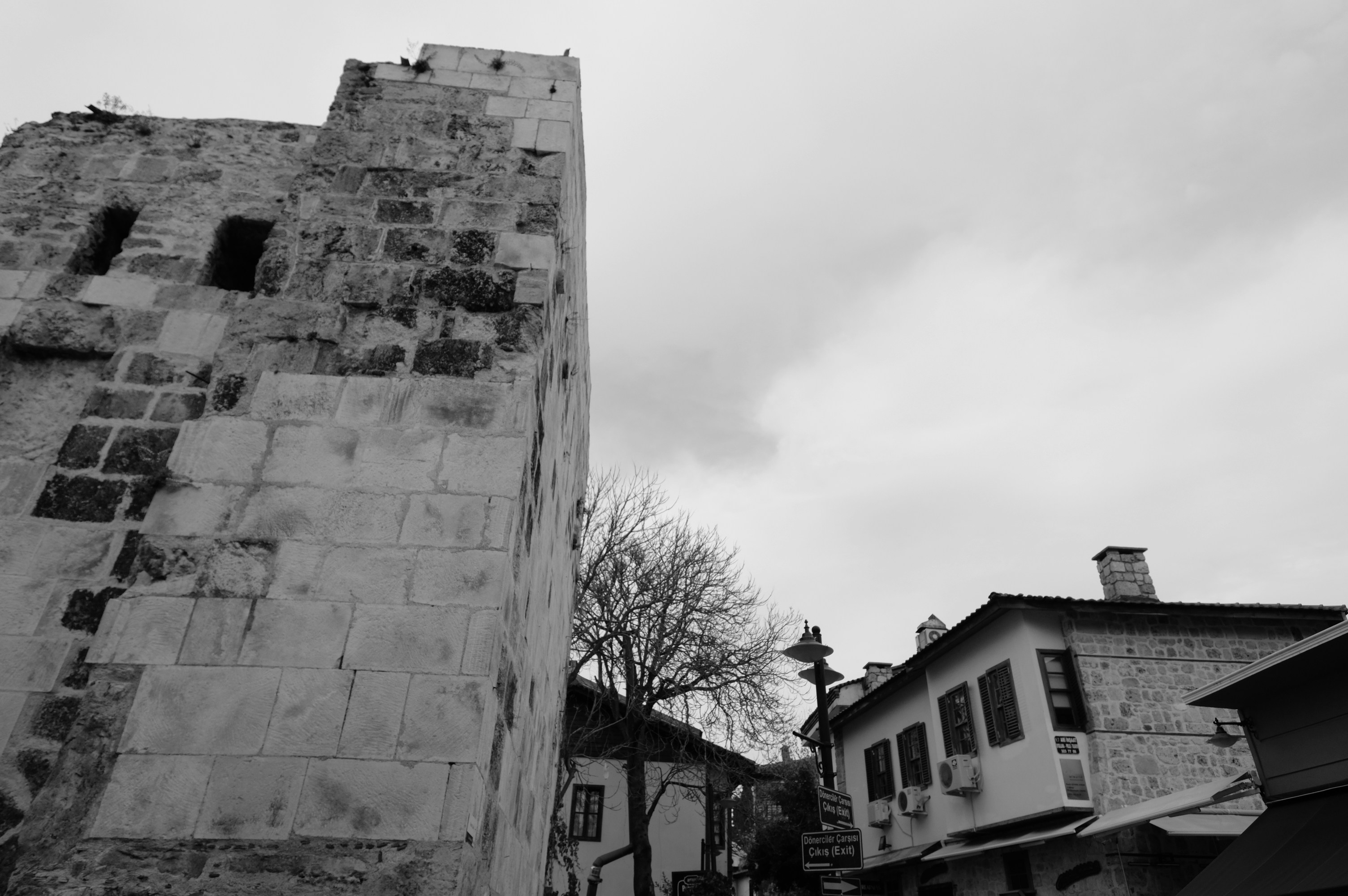 Old stone tower and buildings under cloudy sky