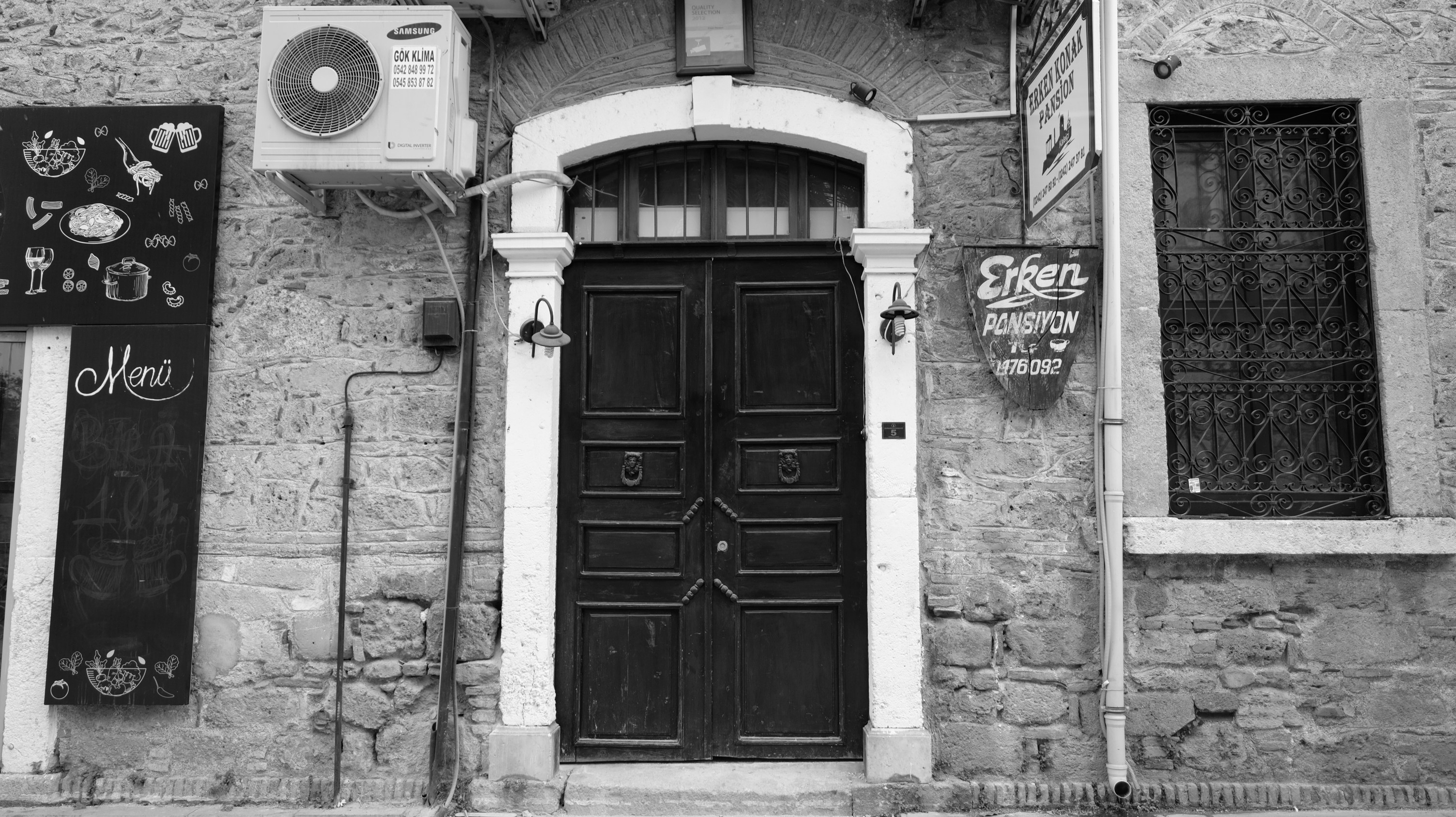 Old wooden doors with stone building exterior and signs