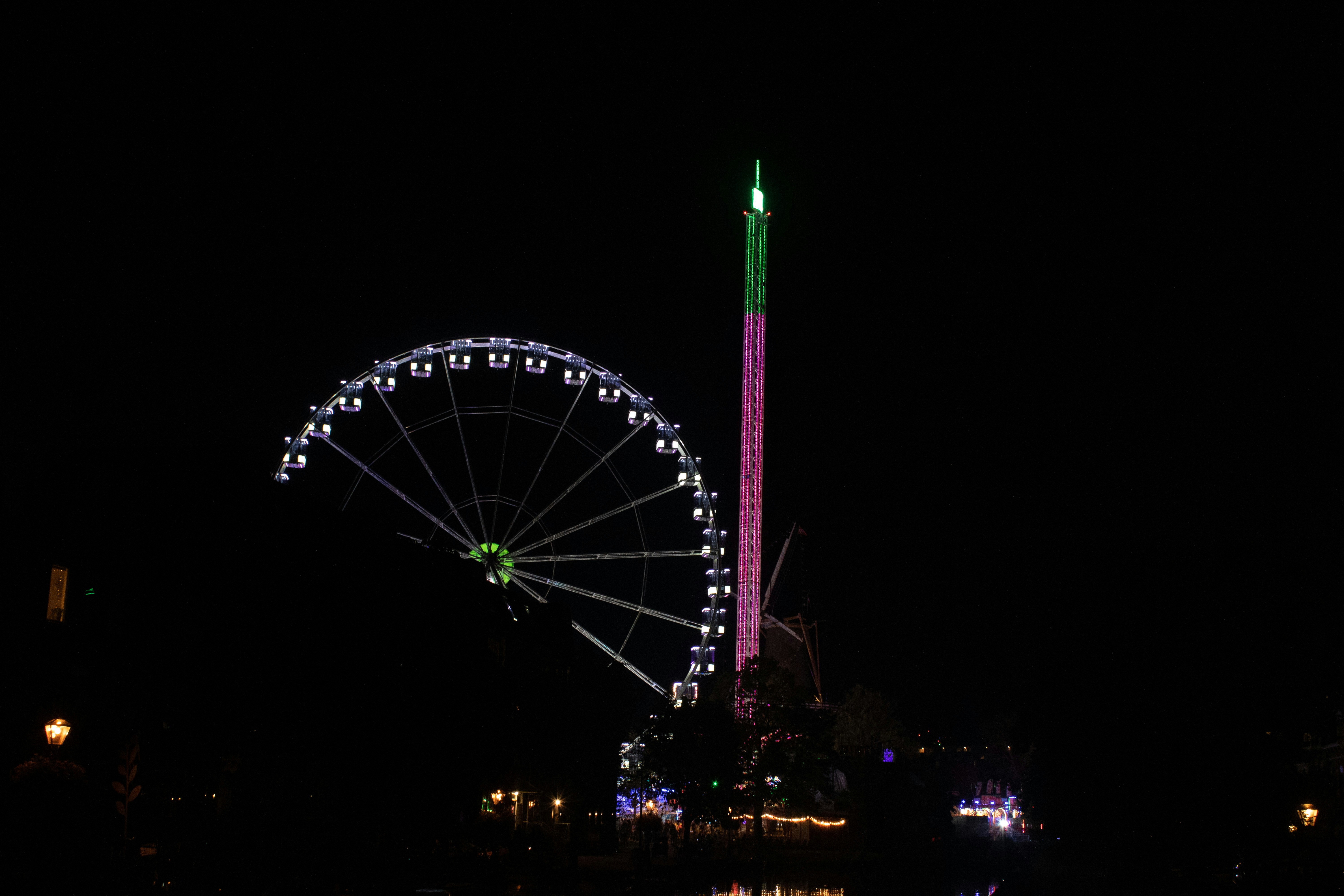 Amusement park rides at night with colorful lights