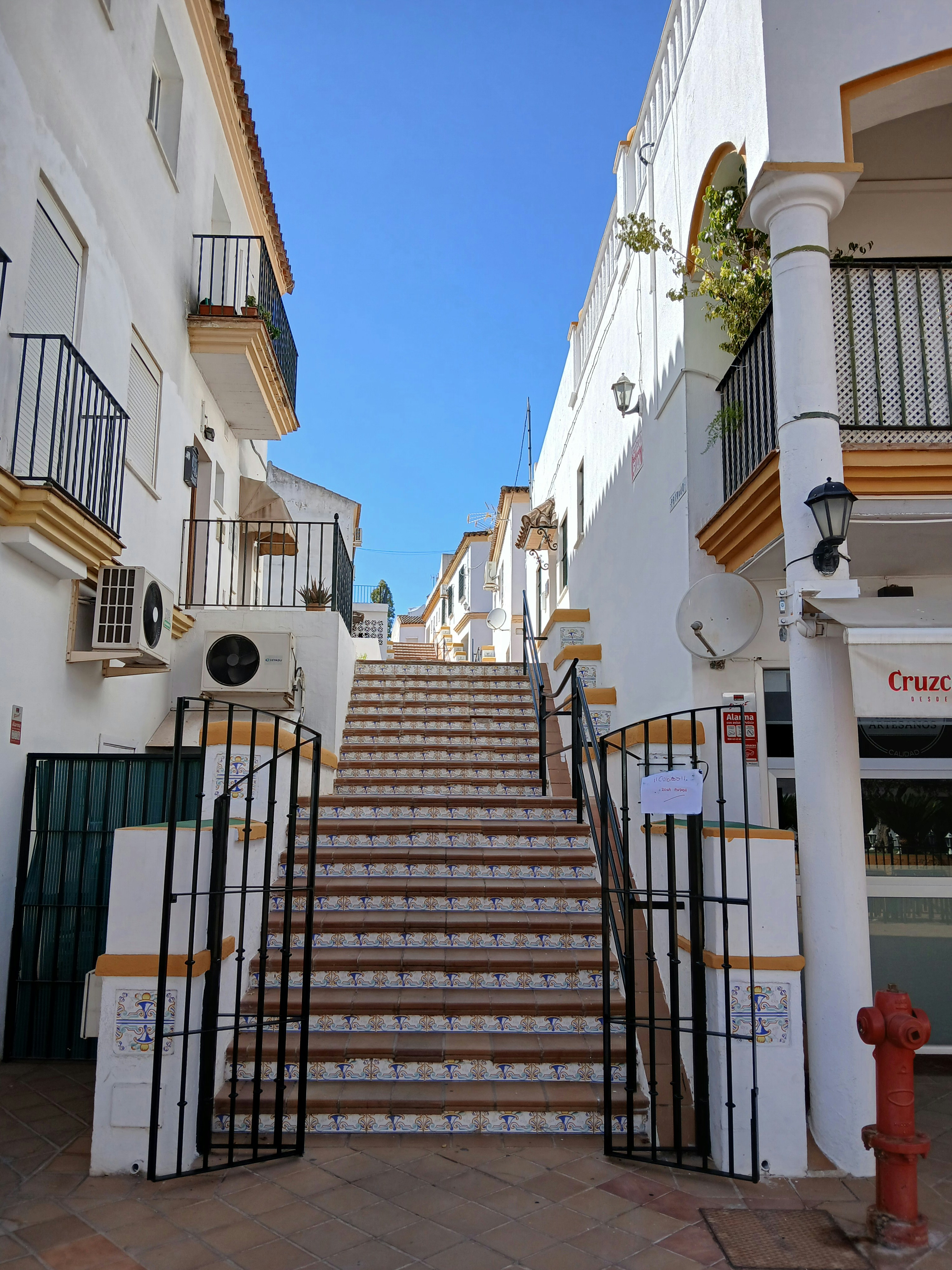 White buildings line a sunlit outdoor staircase.