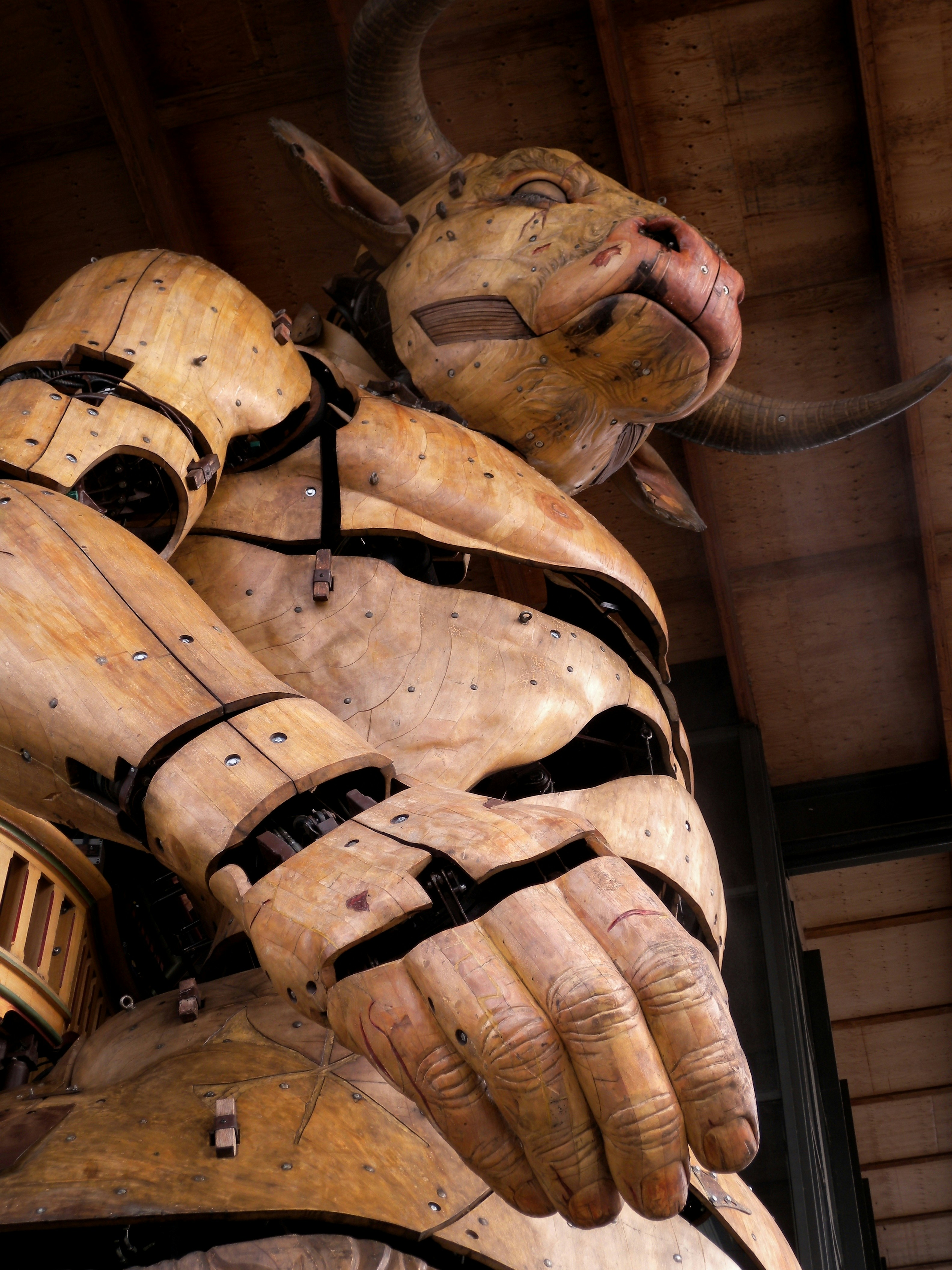 Giant wooden bull automaton with horns and articulated body.