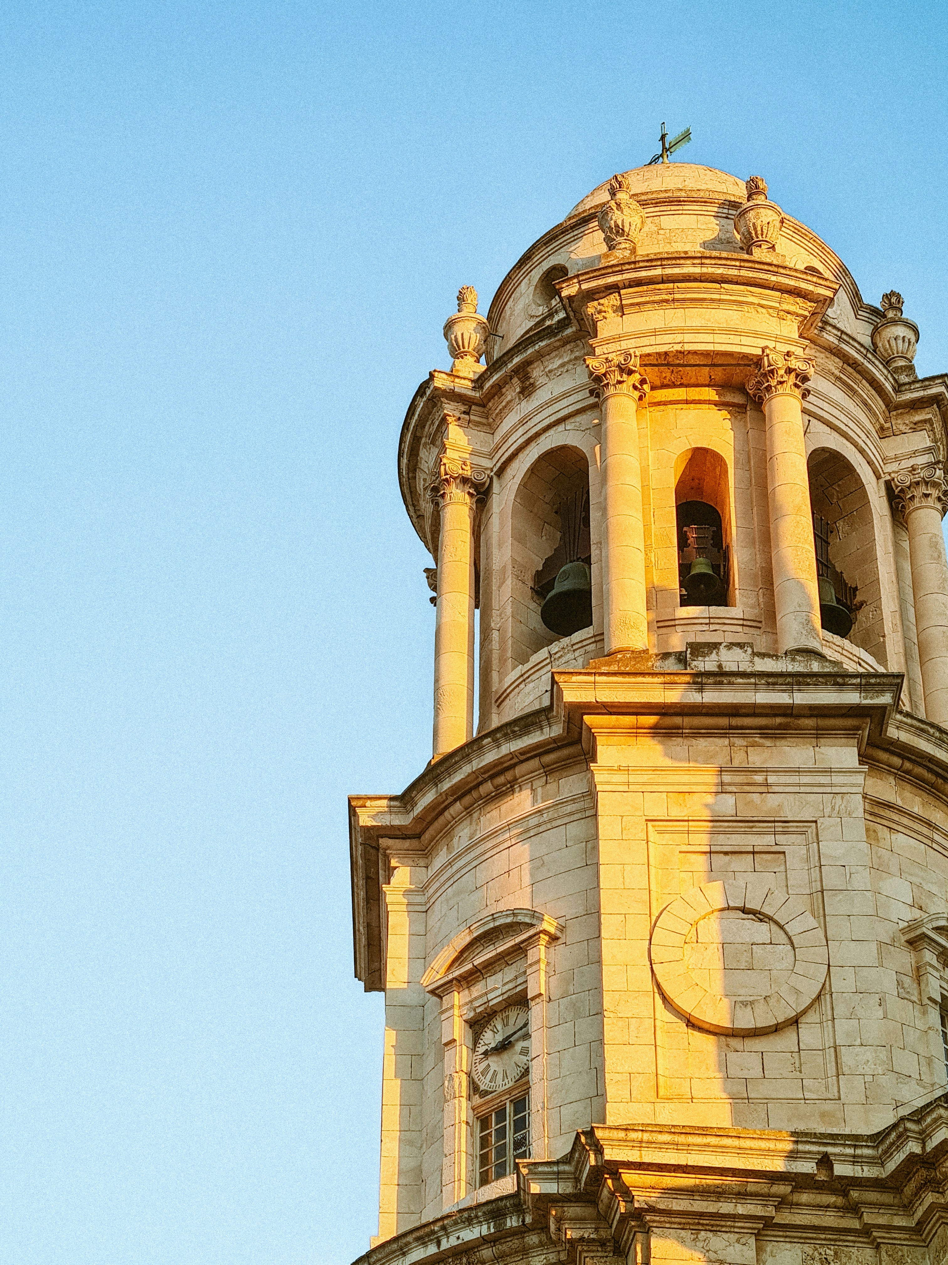 Catedral de Cádiz, junto al mar | Ornate bell tower illuminated by golden hour sunlight
