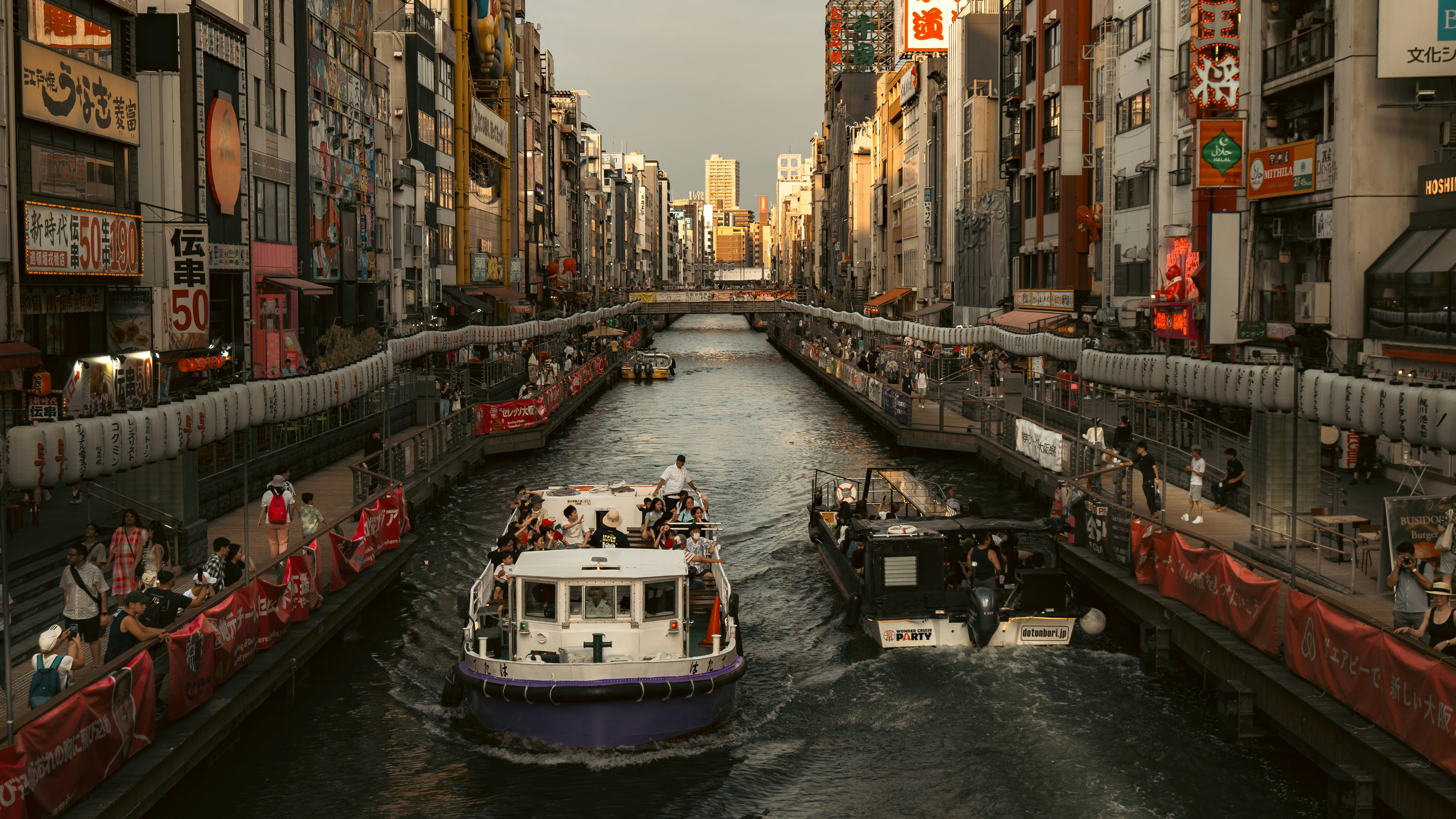 Busy river | Boats travel down a canal lined with buildings.