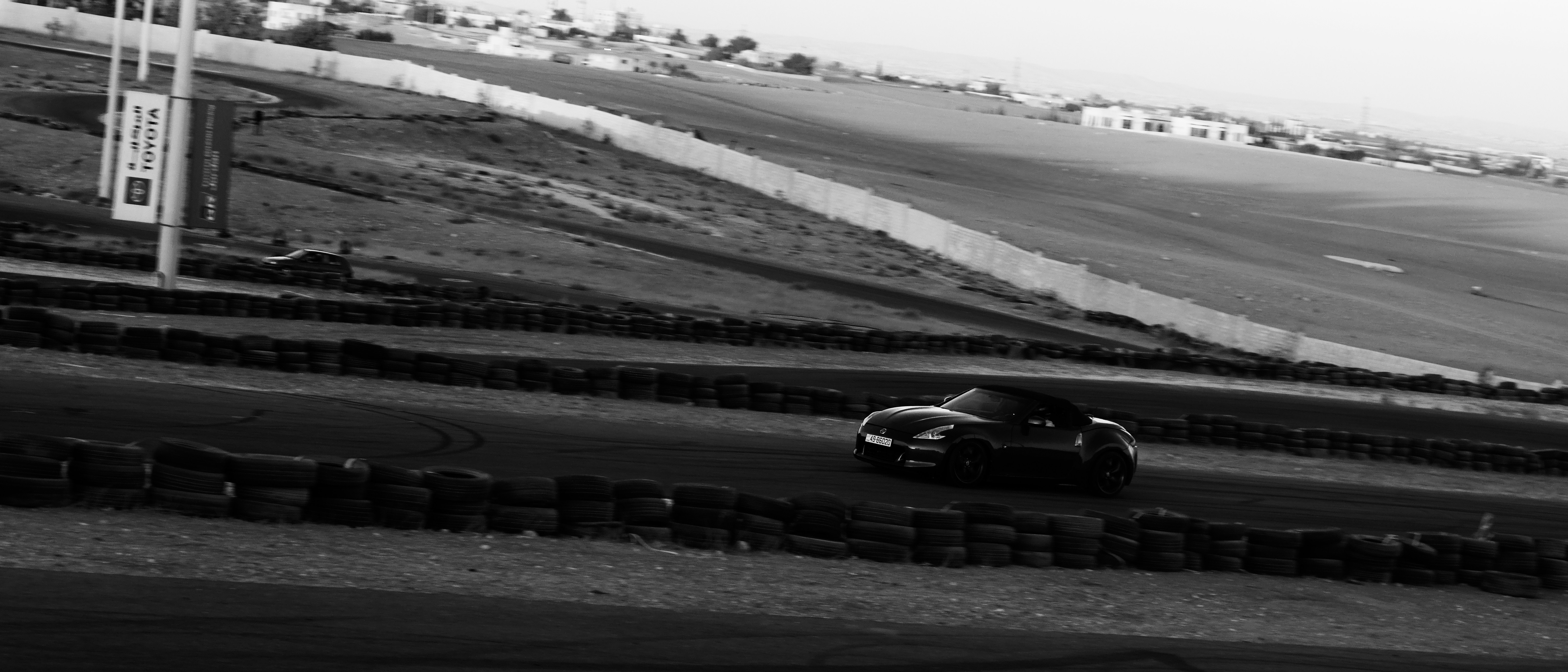 Car driving on a race track with tire barriers