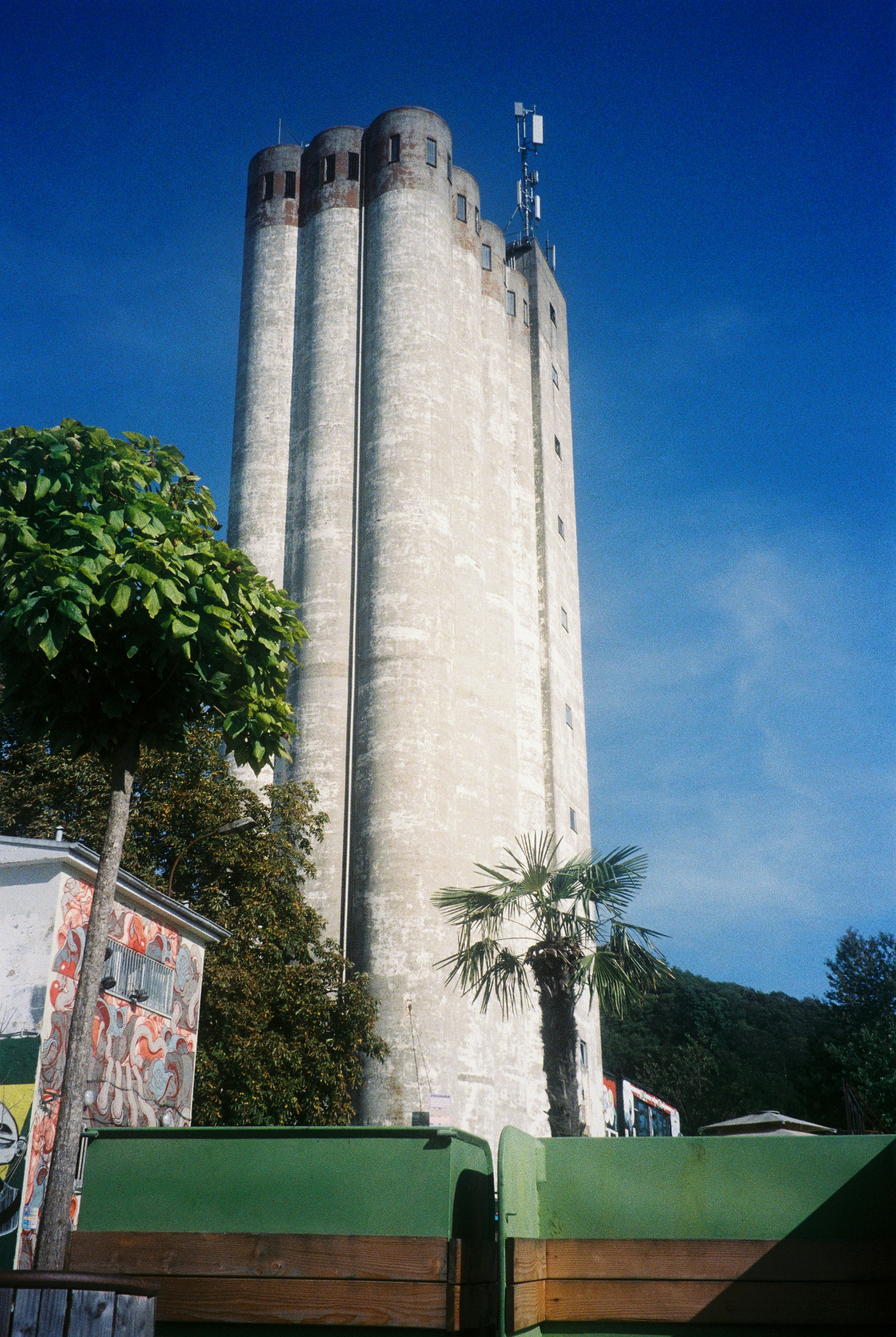 Shot on Kodak UltraMax 400 | Tall concrete silo building with antennas against blue sky