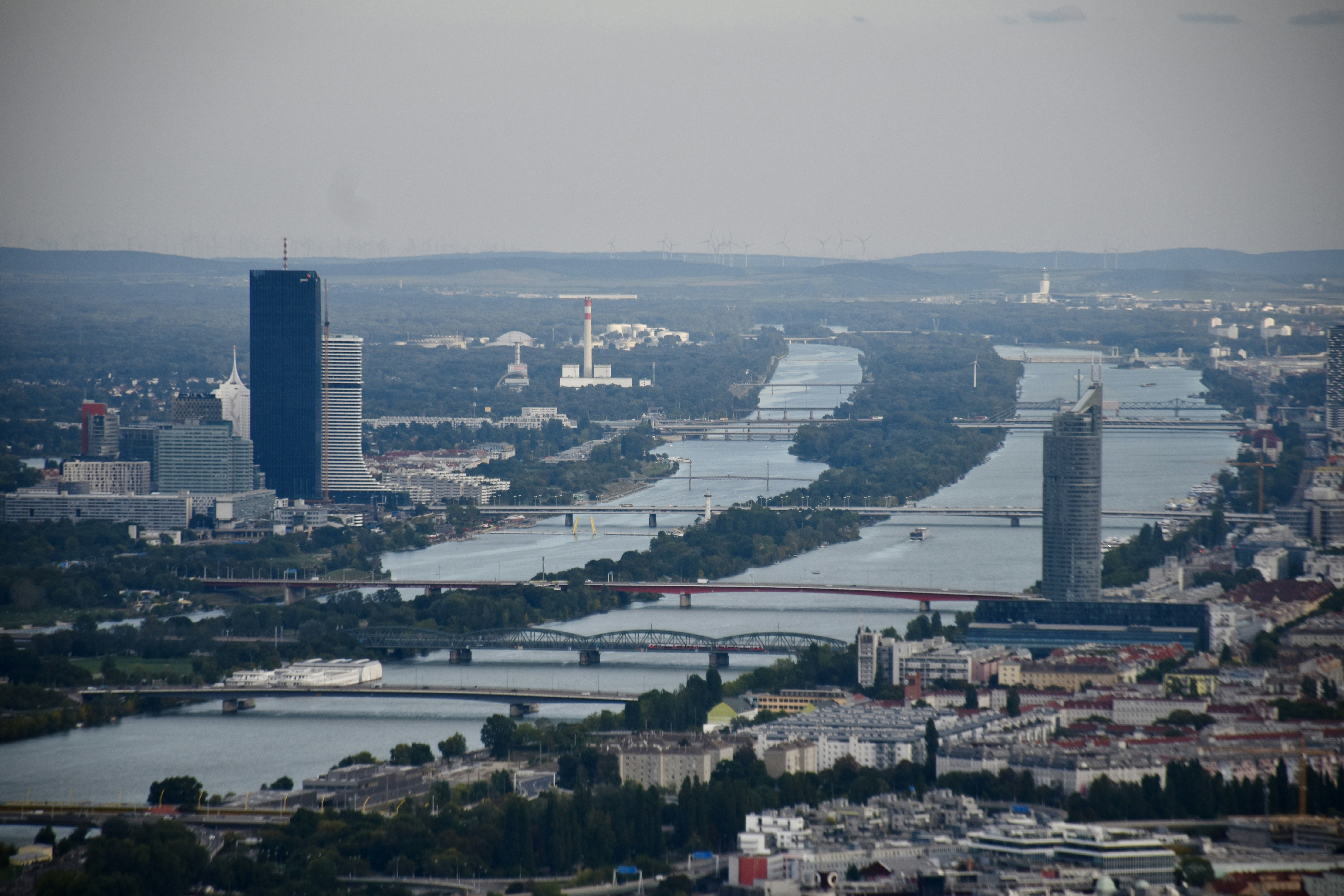 Cityscape with a river and bridges under a hazy sky.