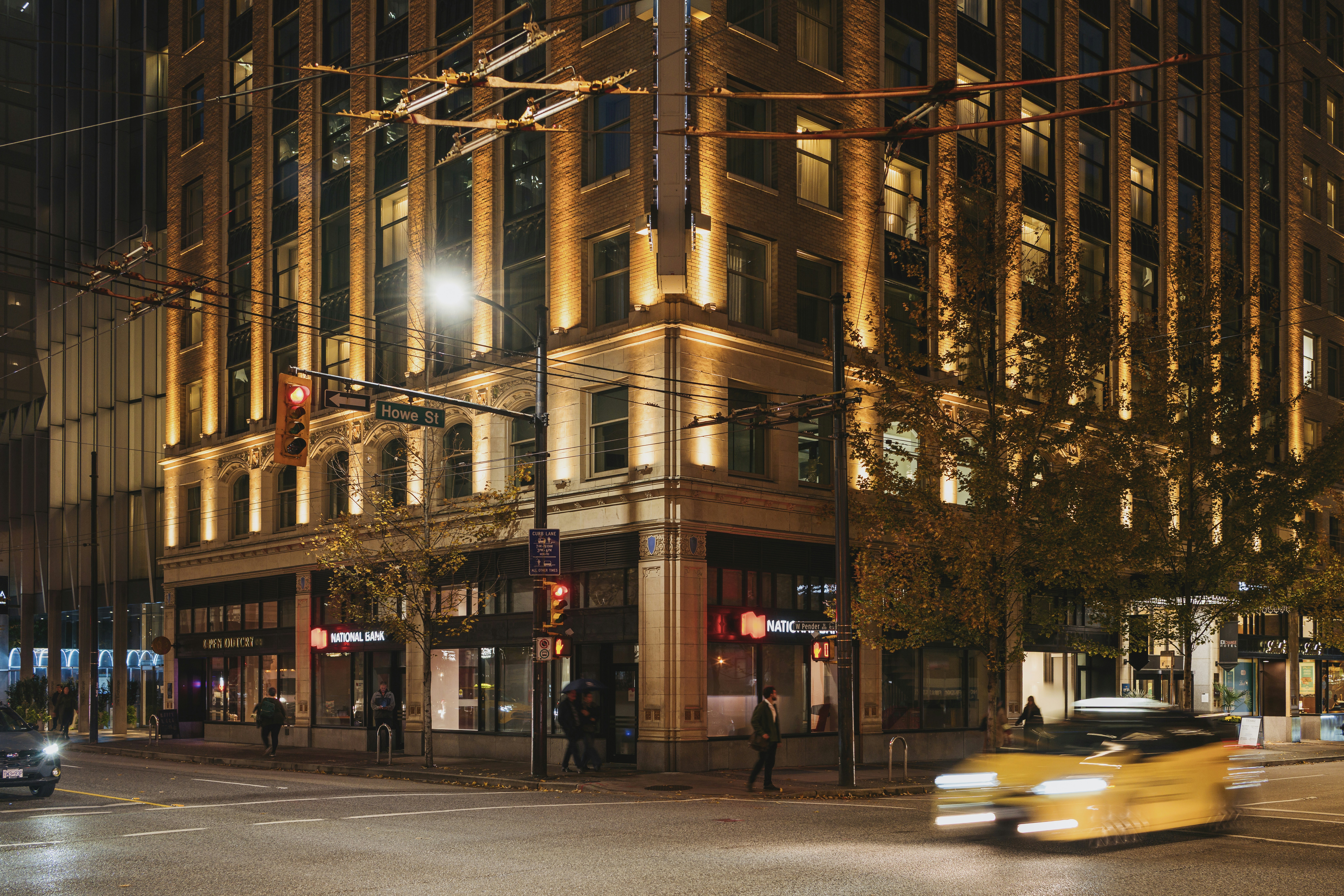Intersection at night with lights | City street corner at night with illuminated building.