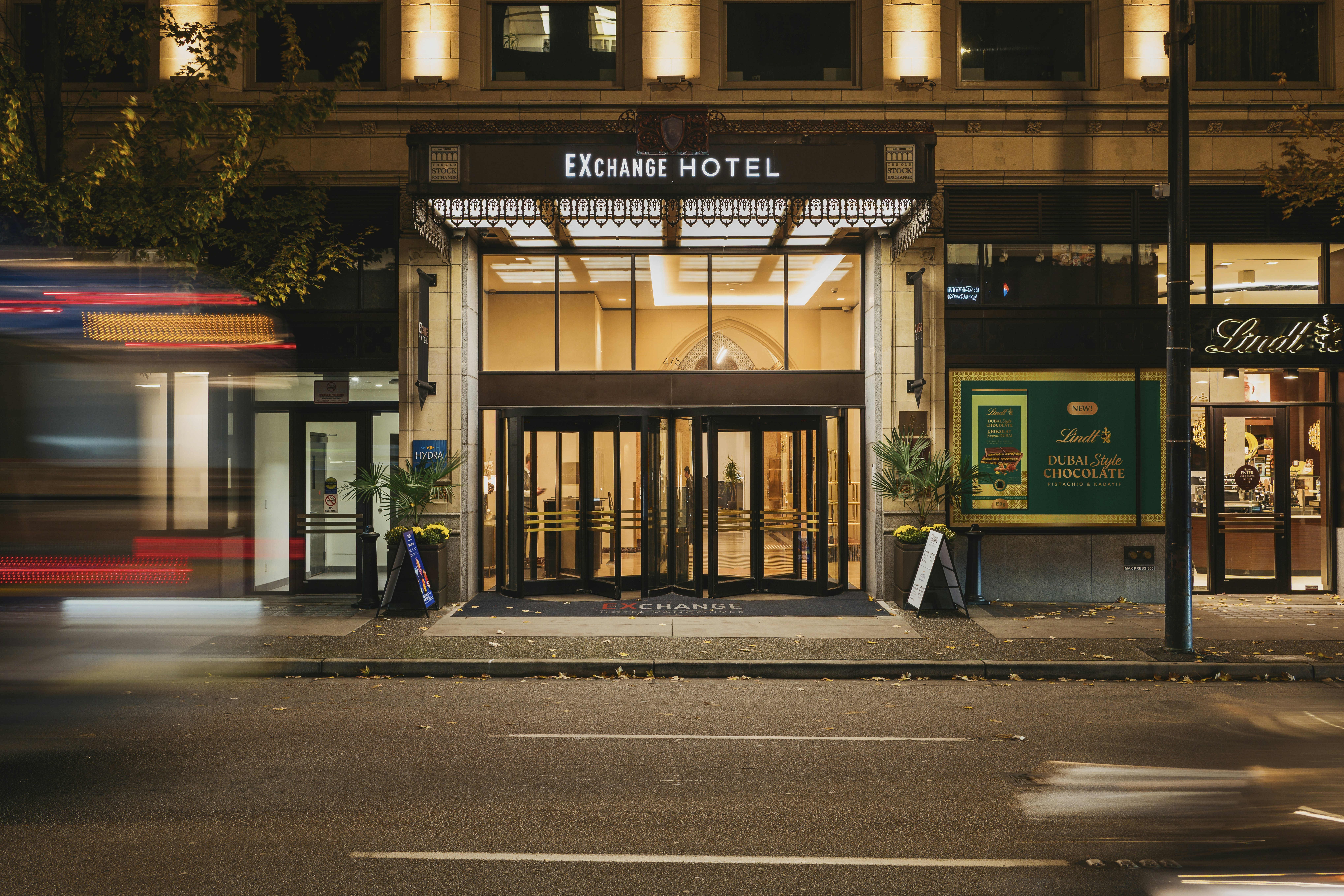 Hotel entrance with light trails and city lights | Elegant hotel entrance at night with blurred traffic