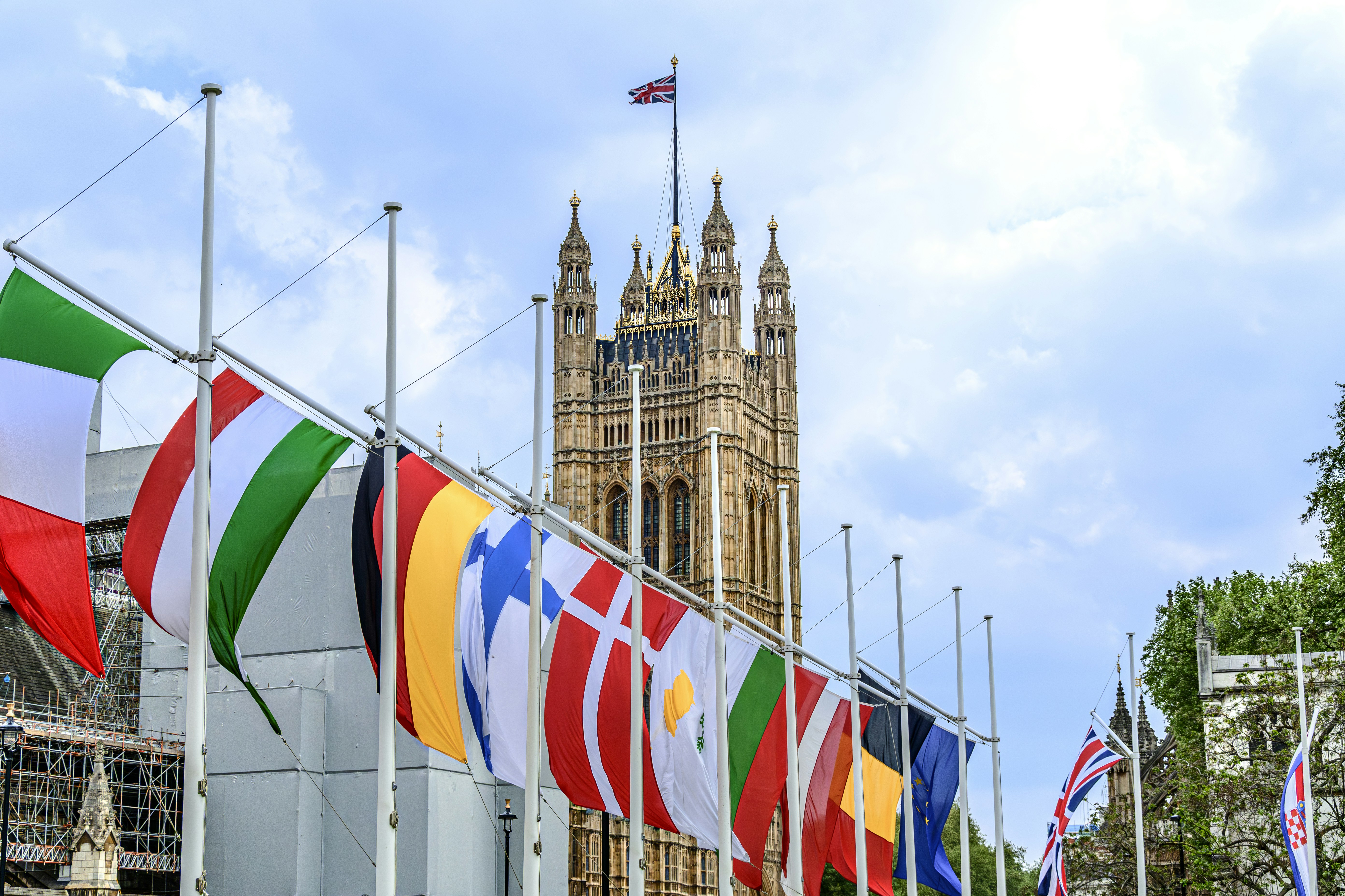 Flags of various countries in front of a building.