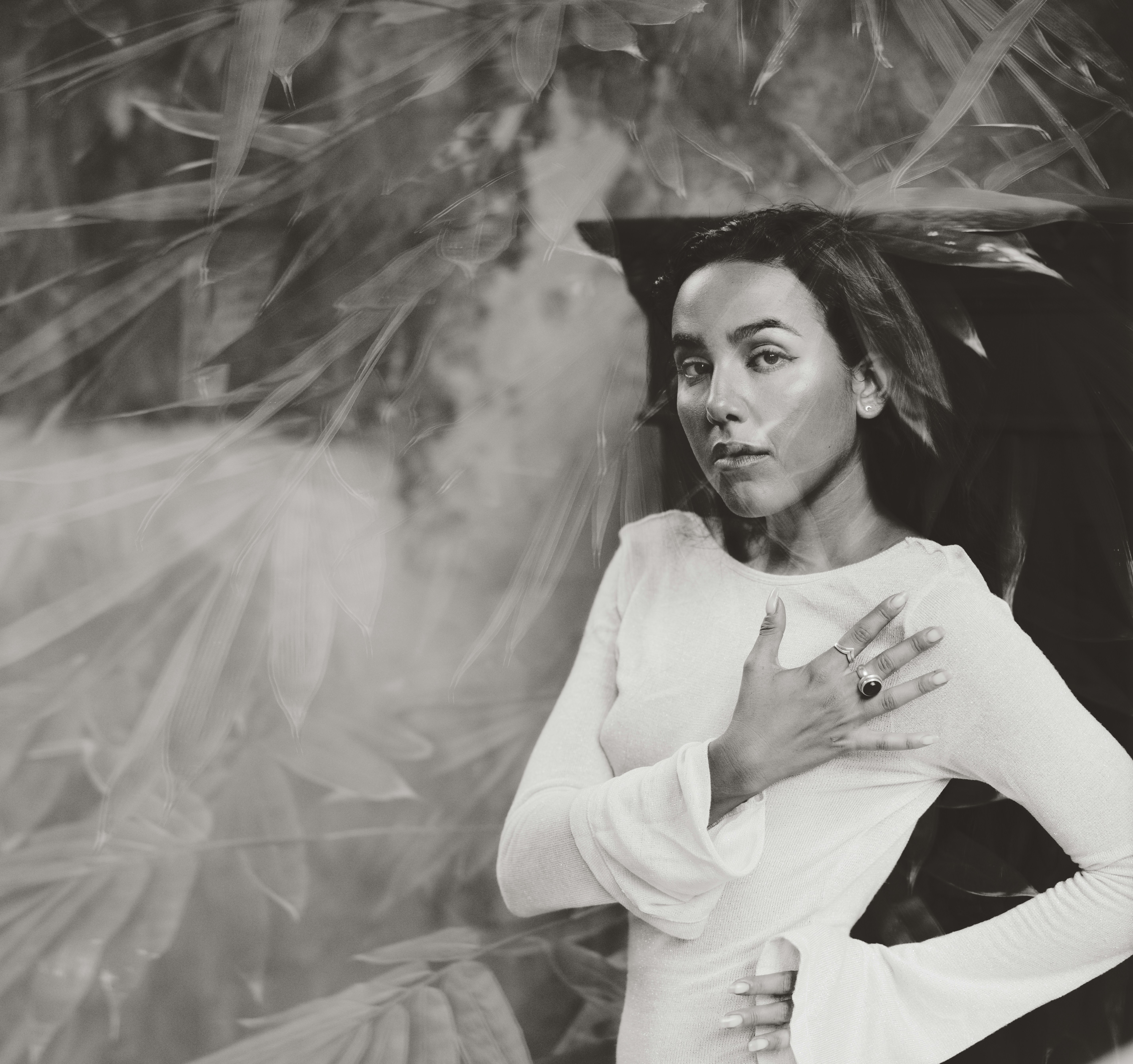 Woman in white dress with hand on chest