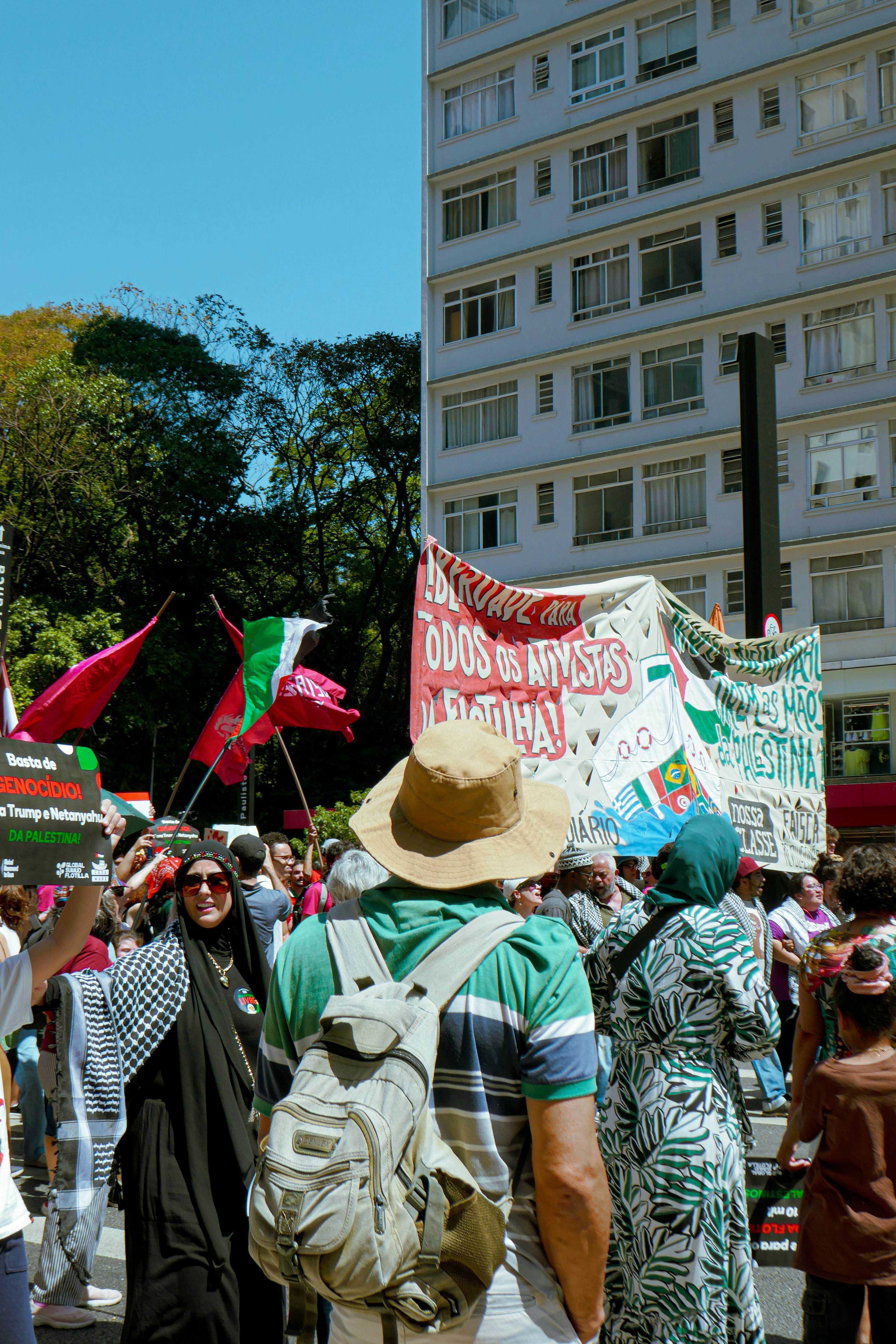 People holding flags and banners at a protest.
